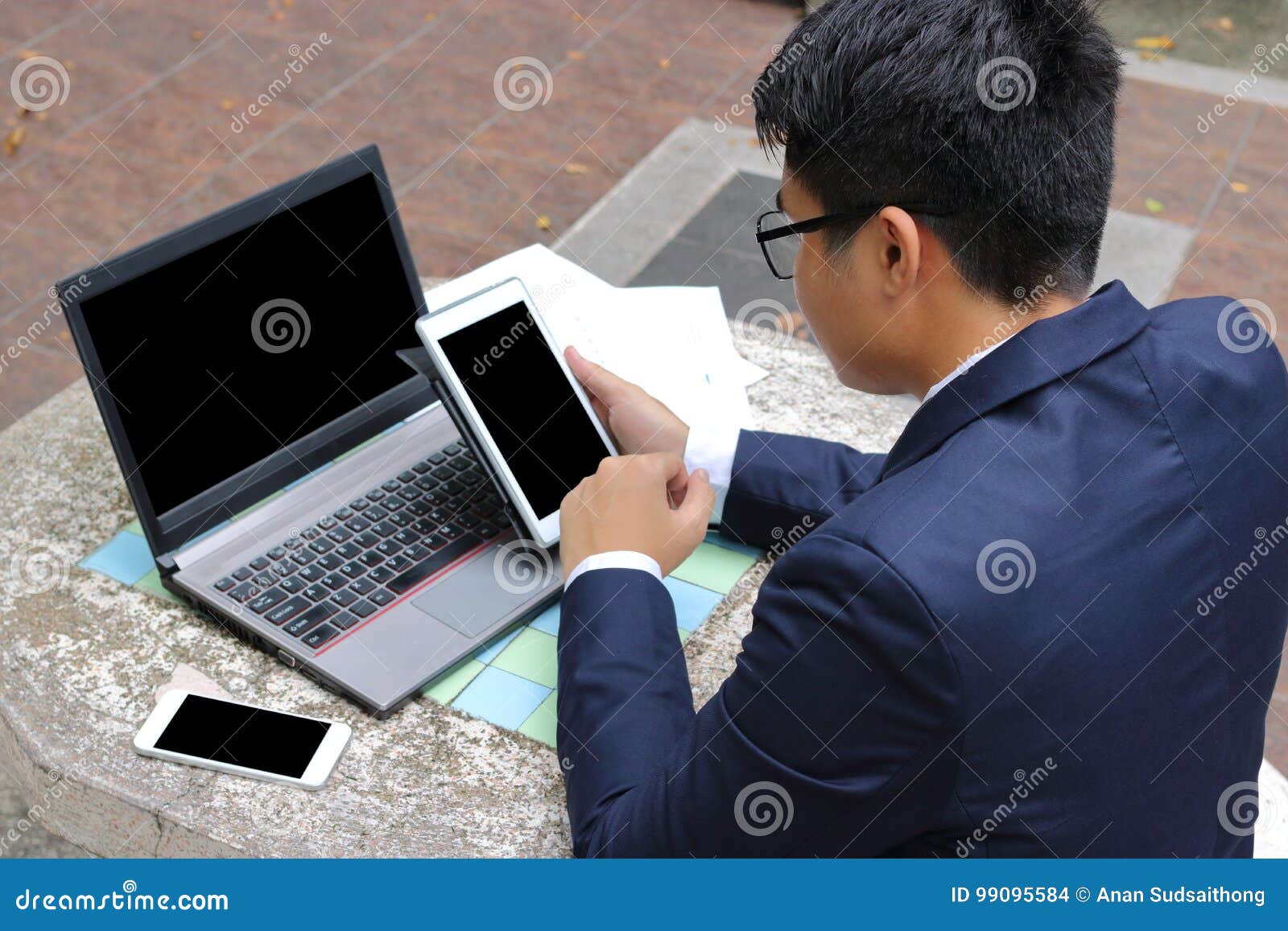 Back View of Young Handsome Businessman is Using Tablet and Laptop for ...