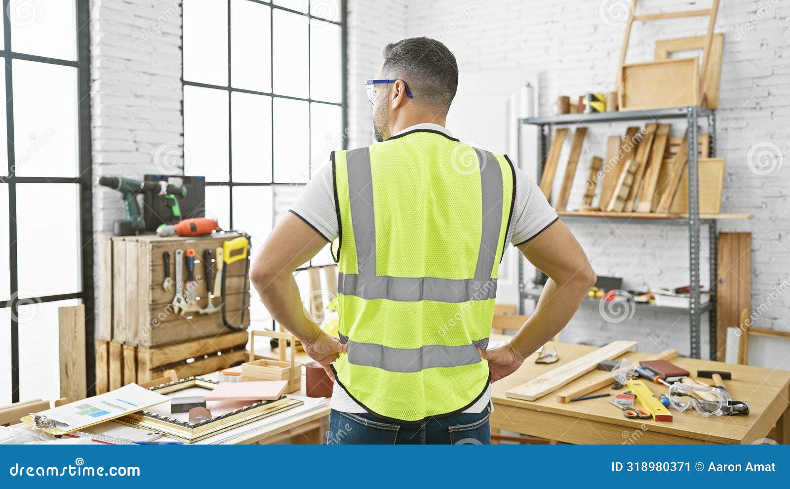 Back View of a Young Hispanic Man with Safety Vest and Glasses in a ...