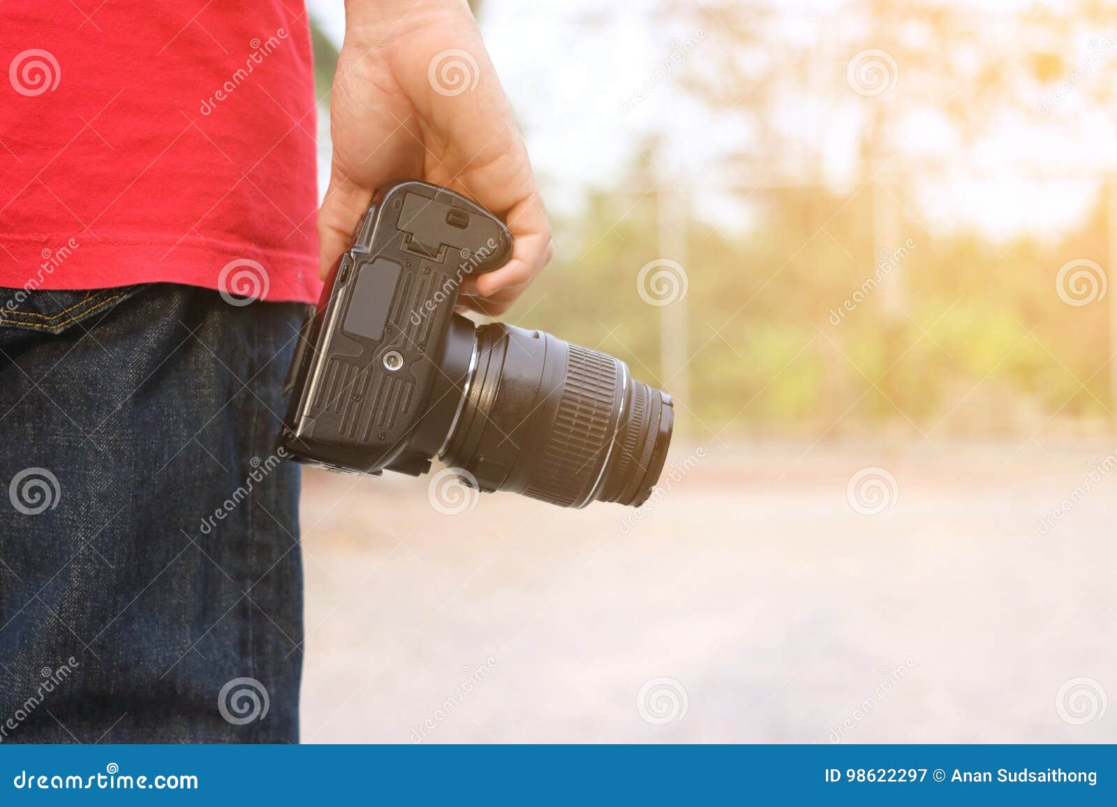 Back View of Young Photographer Holding Camera on Hands with Sunshine ...