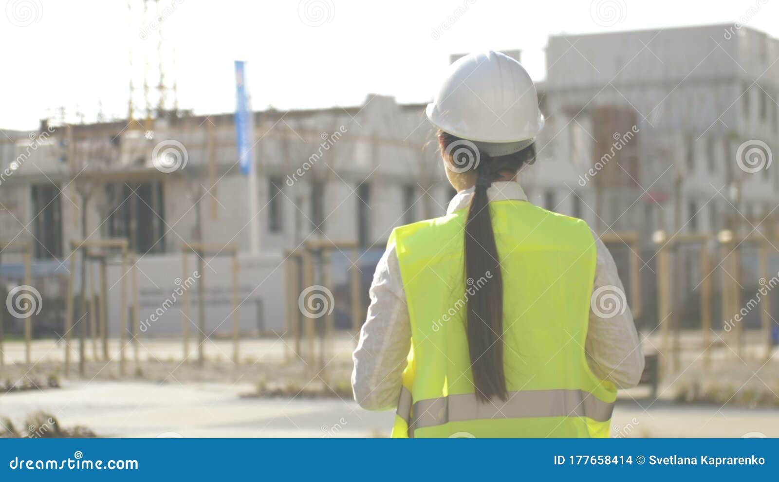 Back View of a Young Woman Builder Who Stands on the Construction Site ...