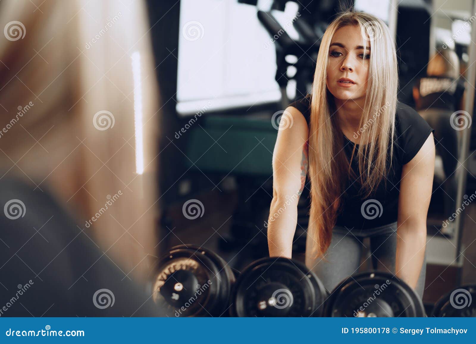 Back View of a Woman Training Her Hands with a Dumbbell in a Gym Stock ...
