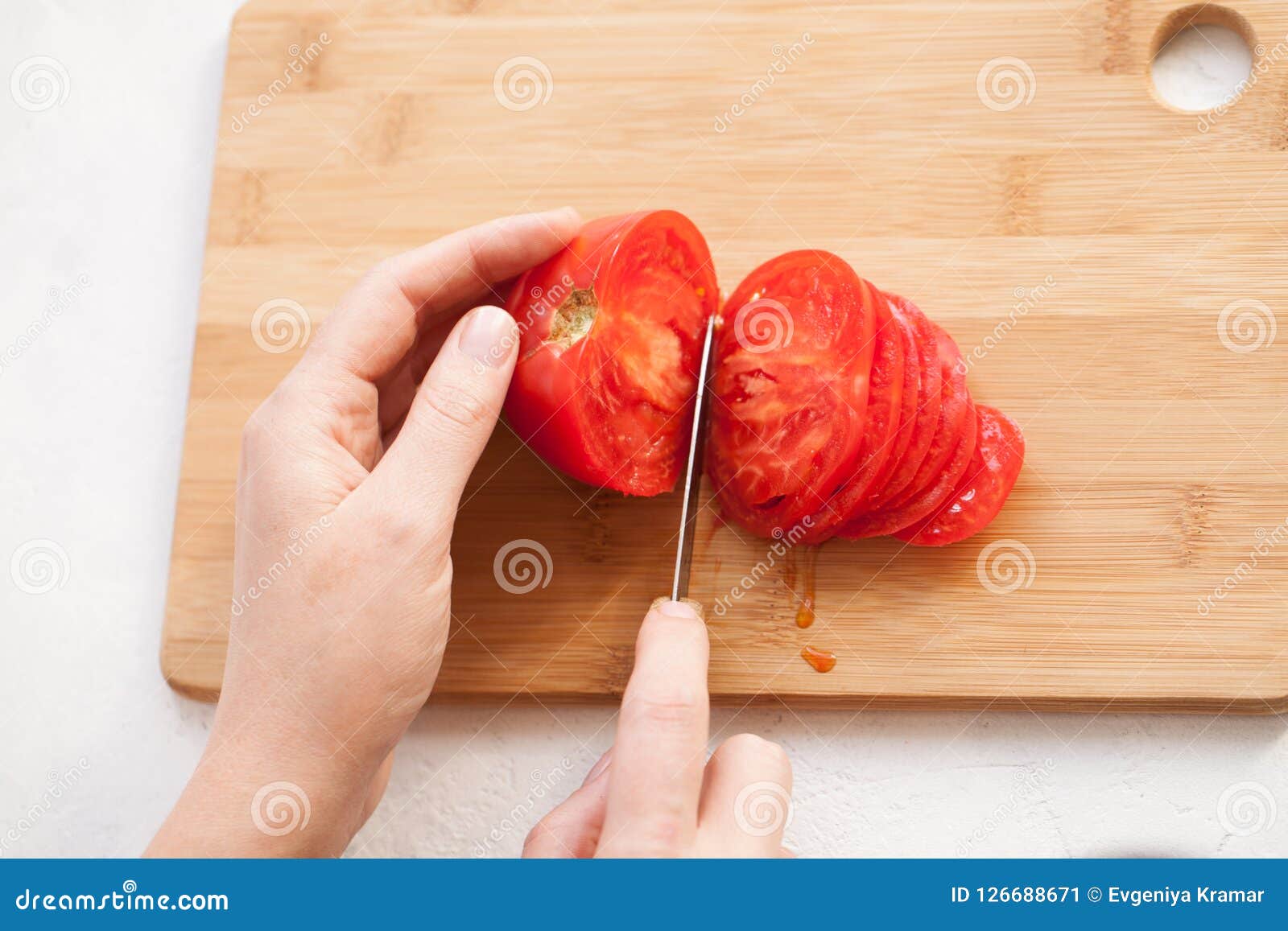 Slicing Half Tomato into Slices on the Kitchen Board Stock Image ...