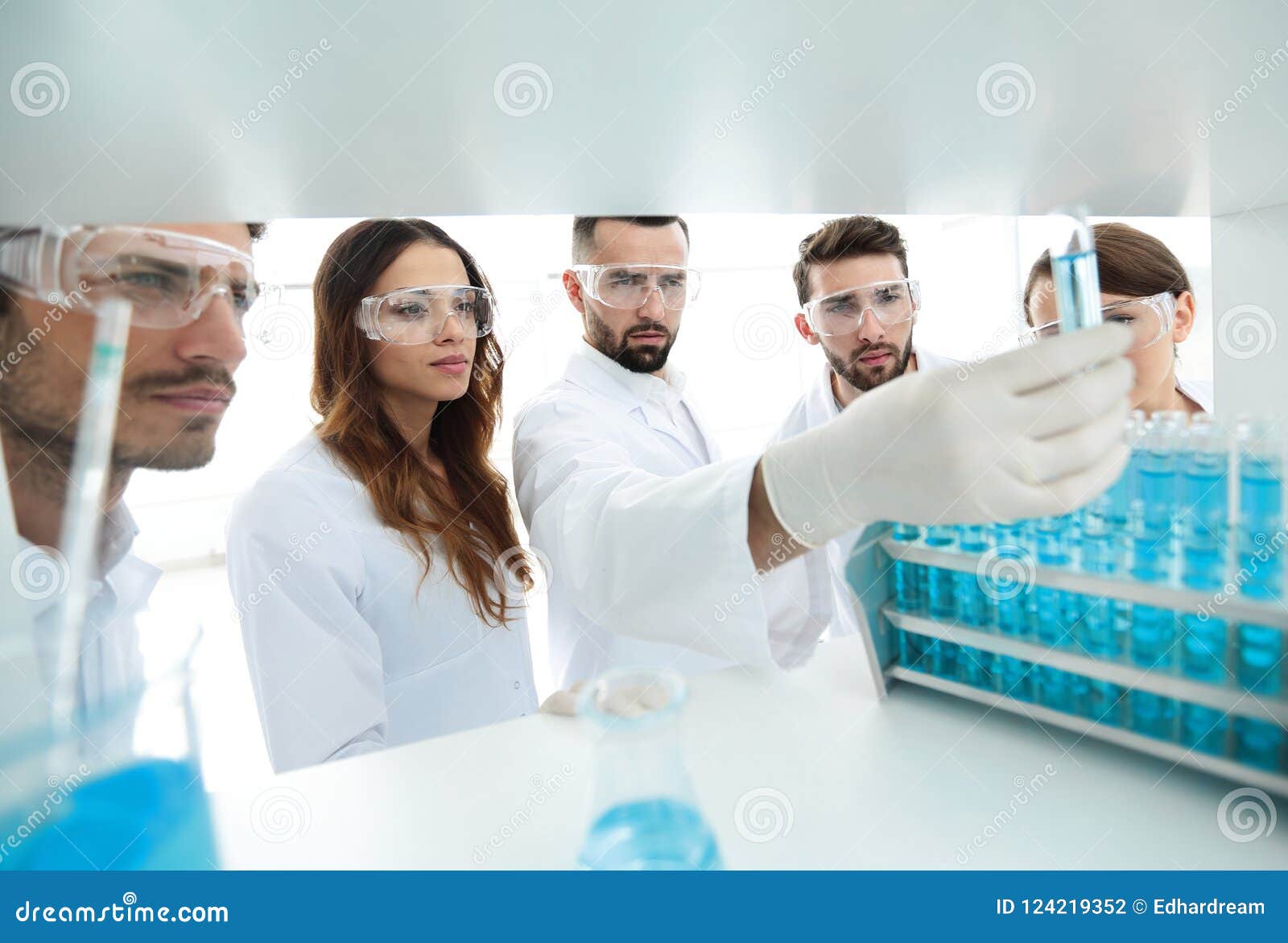 Background Image is a Group of Microbiologists Studying the Liquid in ...