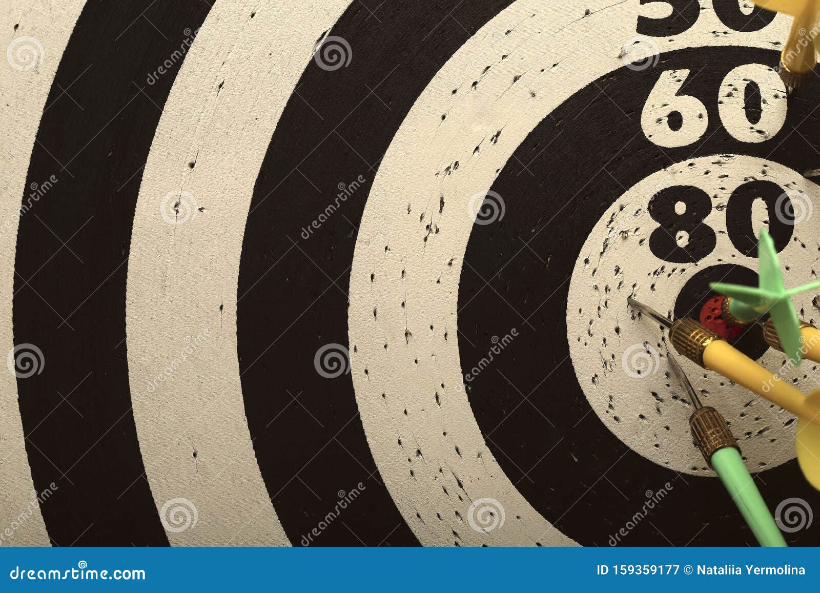 The Background of the Target is Darts with Dart Marks that Hit the ...