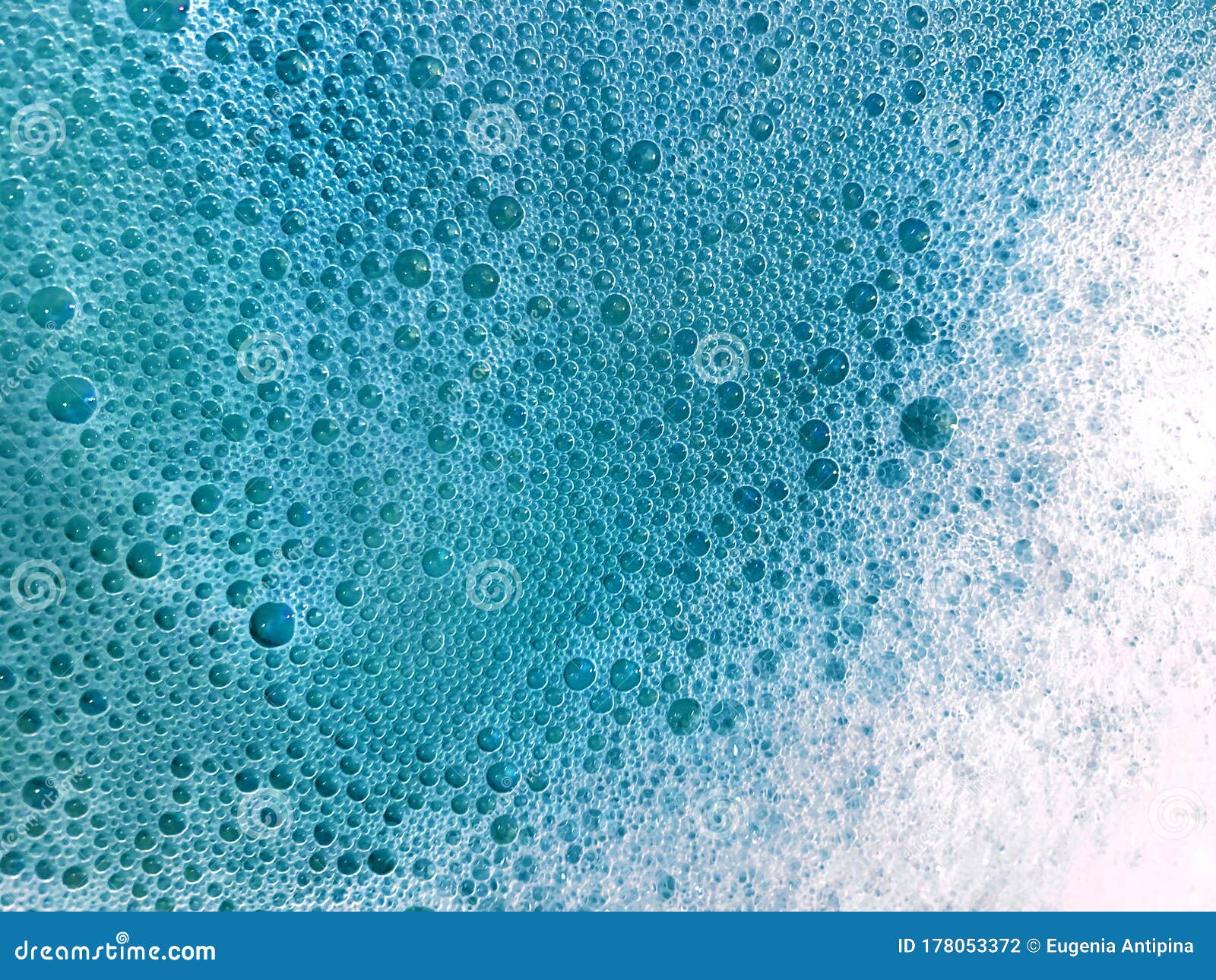 Background With White Soap Foam In Blue Turquoise Bright Water Ocean