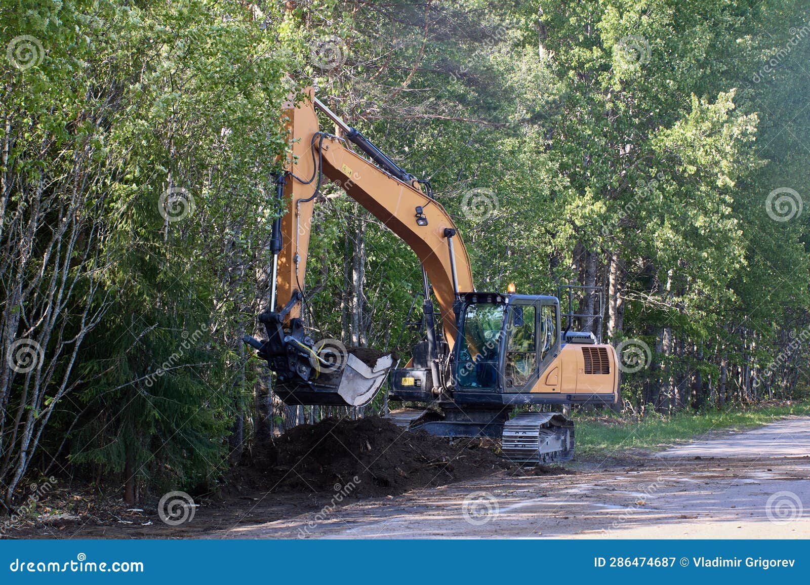Backhoe Deepens Drainage Ditch on Country Road. Stock Image - Image of ...