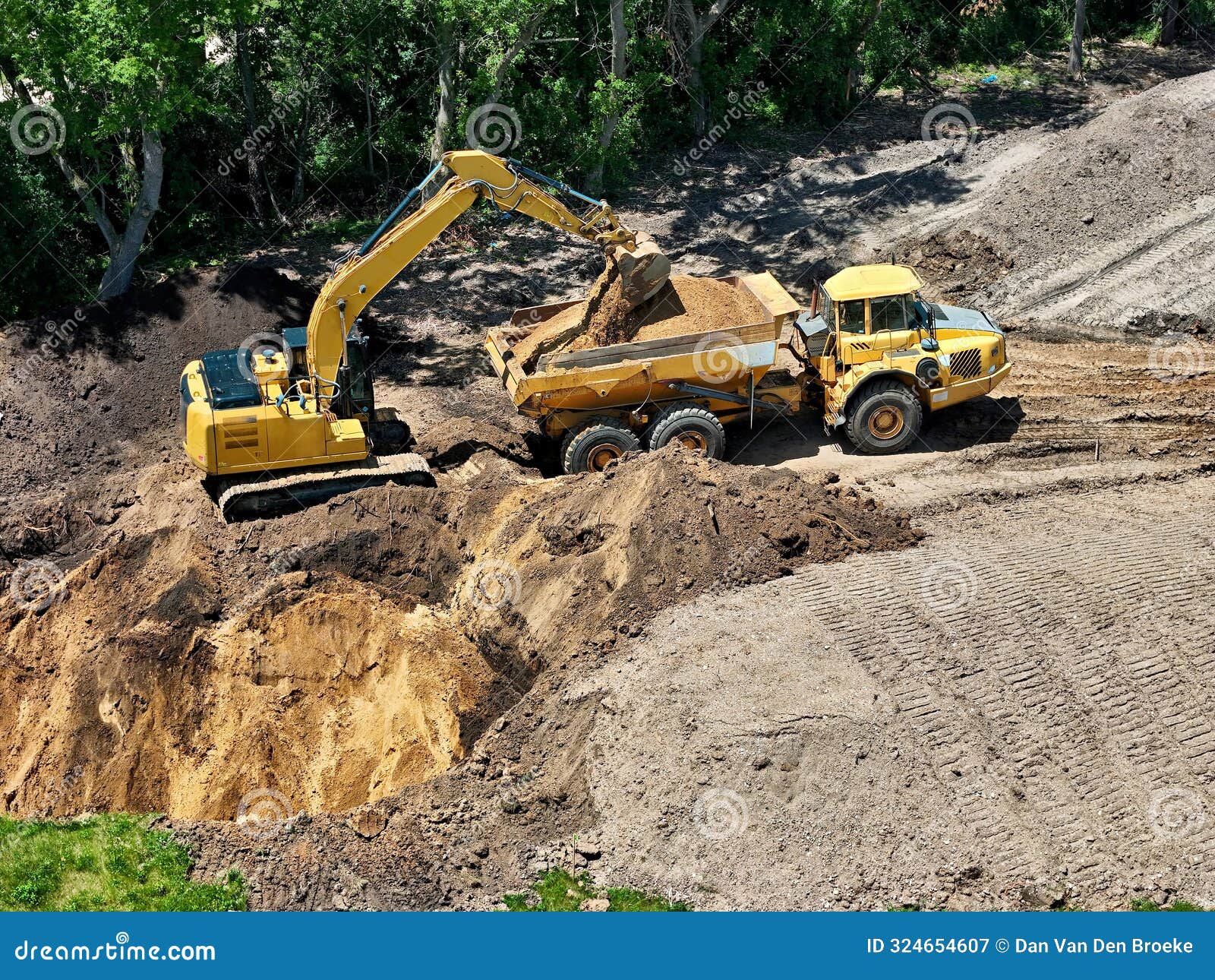 Backhoe Loading a Large Dump Truck at a Construction Site Stock Image ...