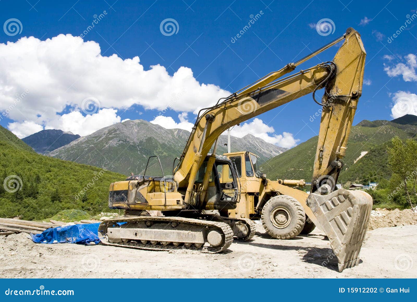 Backhoe Working Against a Mountain Landscape Stock Photo - Image of ...