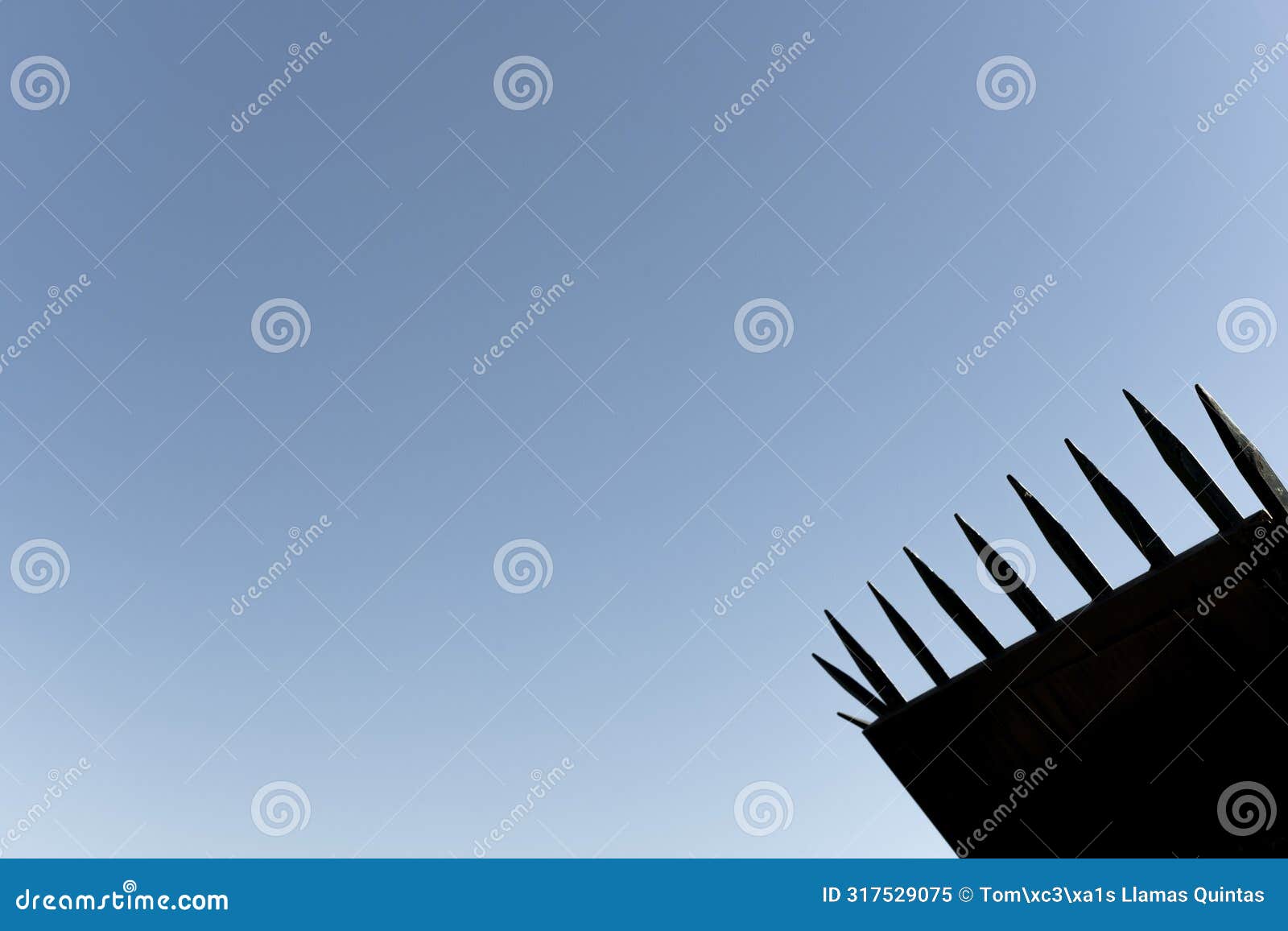 Backlit Spikes on Top of a Perimeter Fence Stock Image - Image of ...