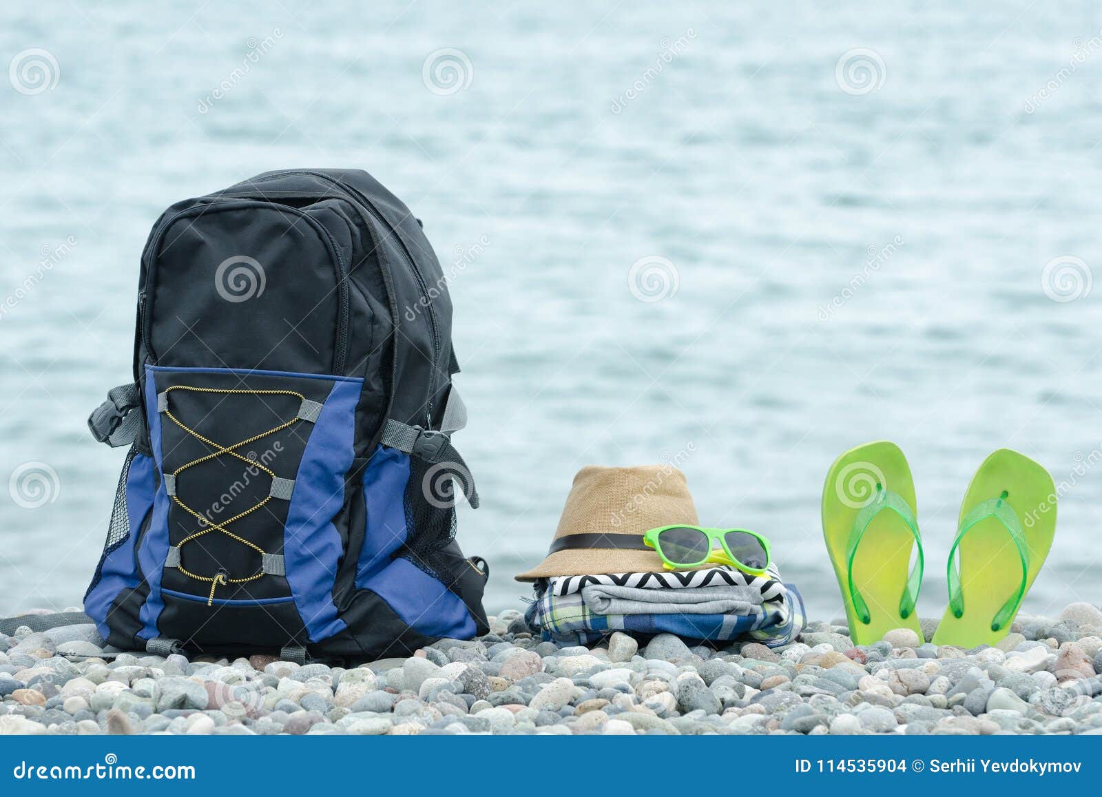 Backpack, Hat and Flip-flops on the Pebble Beach. Sea in the Background ...