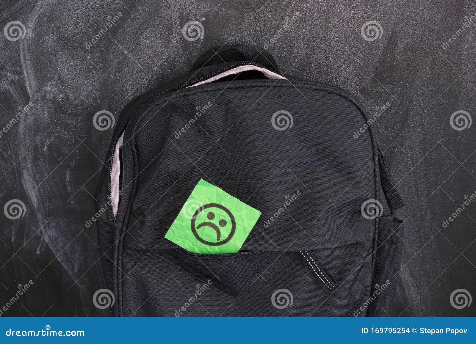 Backpack with a Sad Face on Paper Note Standing Against Blackboard ...