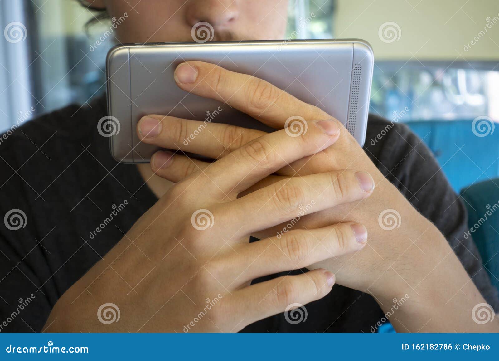 Backside of a Smartphone, Holded by the Hand of a Teenager in Cap Stock ...