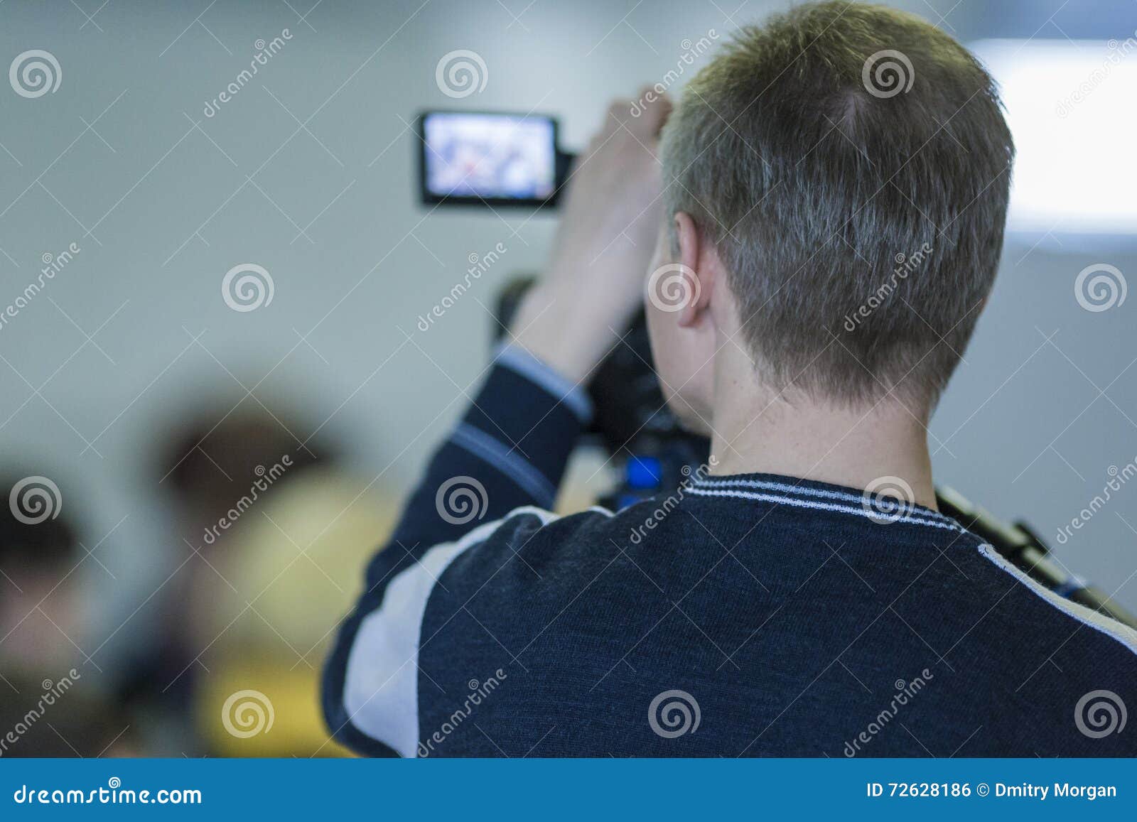 Backview of Professional Cameraman Filming Using Professional Vi ...