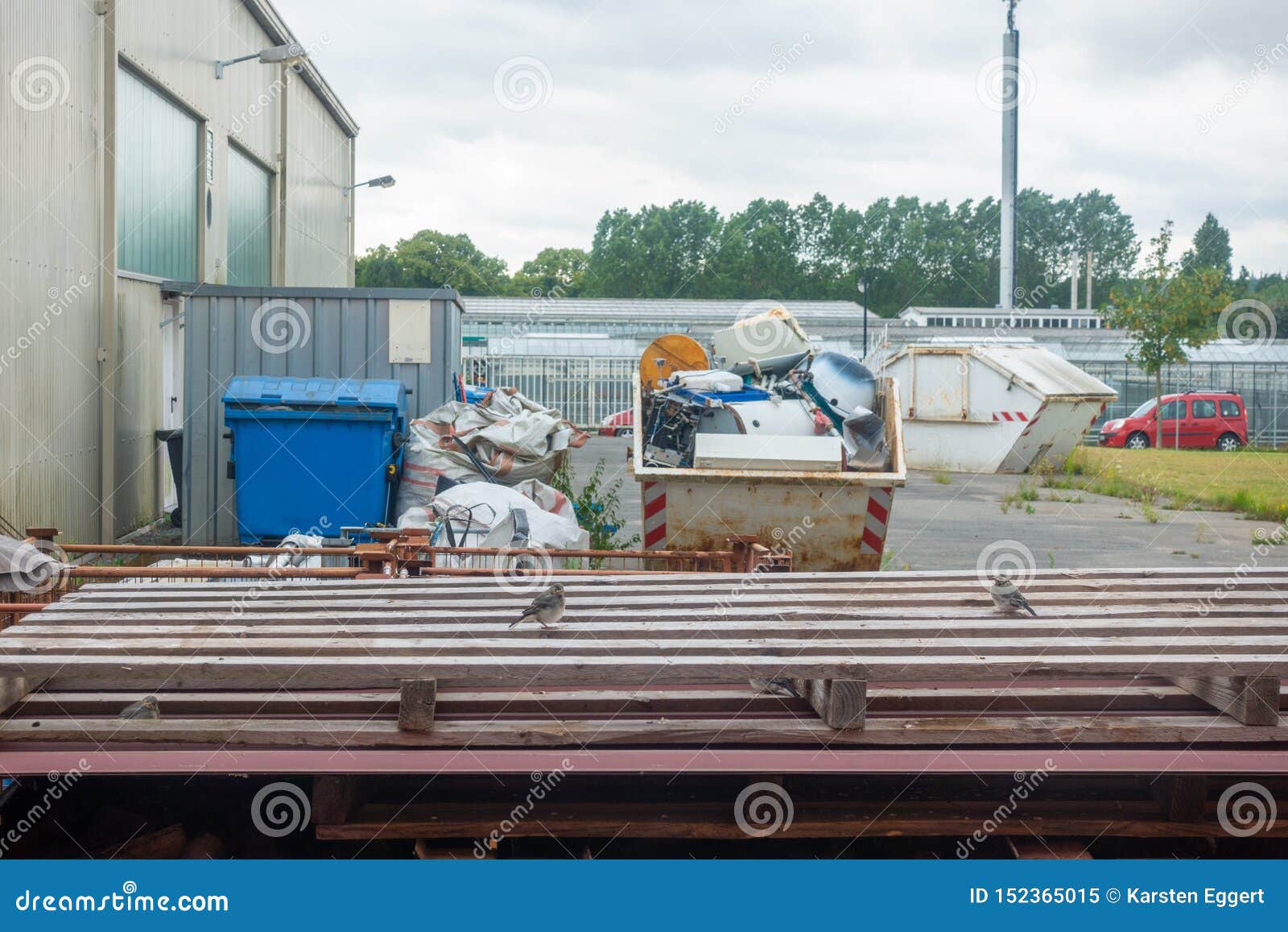 In a Backyard There are Garbage Containers and a Container with Scrap ...