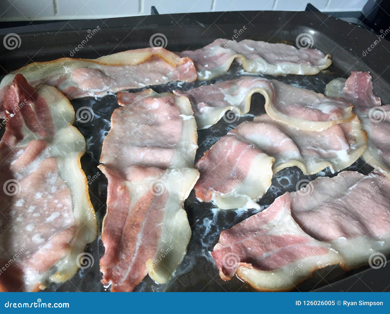 Bacon cooking on a tray stock image. Image of plate - 126026005