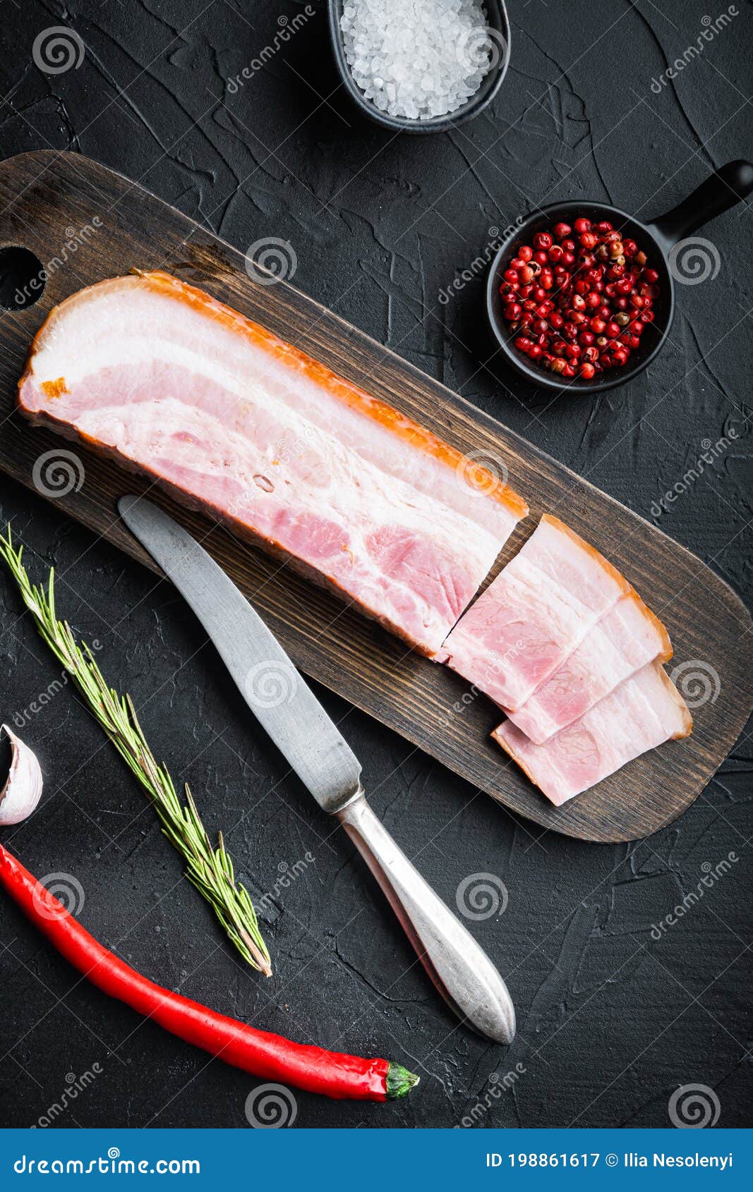 Bacon Pancetta Cut and Sliced with Herbs on Black Background, Top View ...