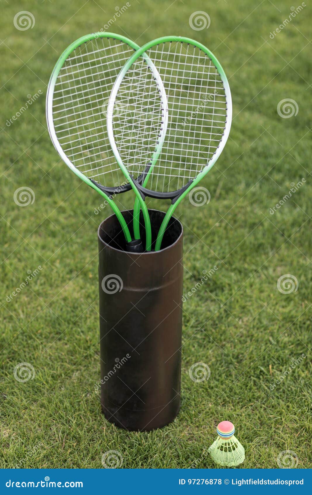 Badminton Racquets in Container and Shuttlecock on Green Grass Stock ...