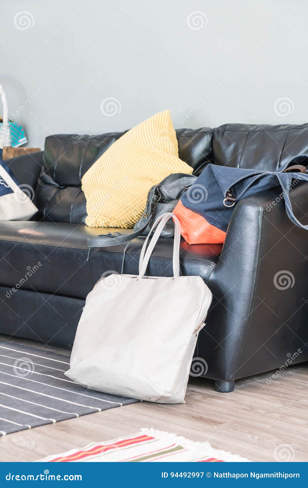 Bag on black leather sofa stock image. Image of couch - 94492997
