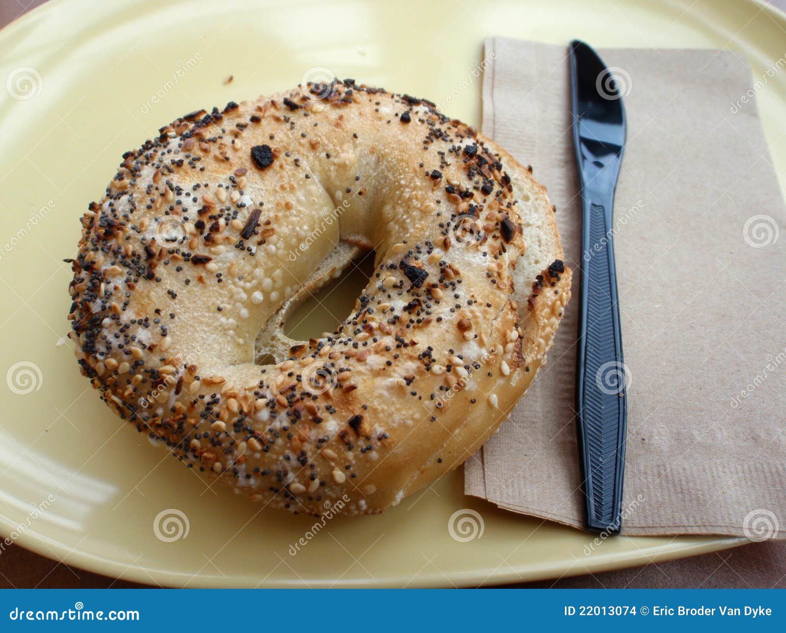 Bagel and Plastic Knife on a Yellow Plate Stock Photo - Image of fuel ...