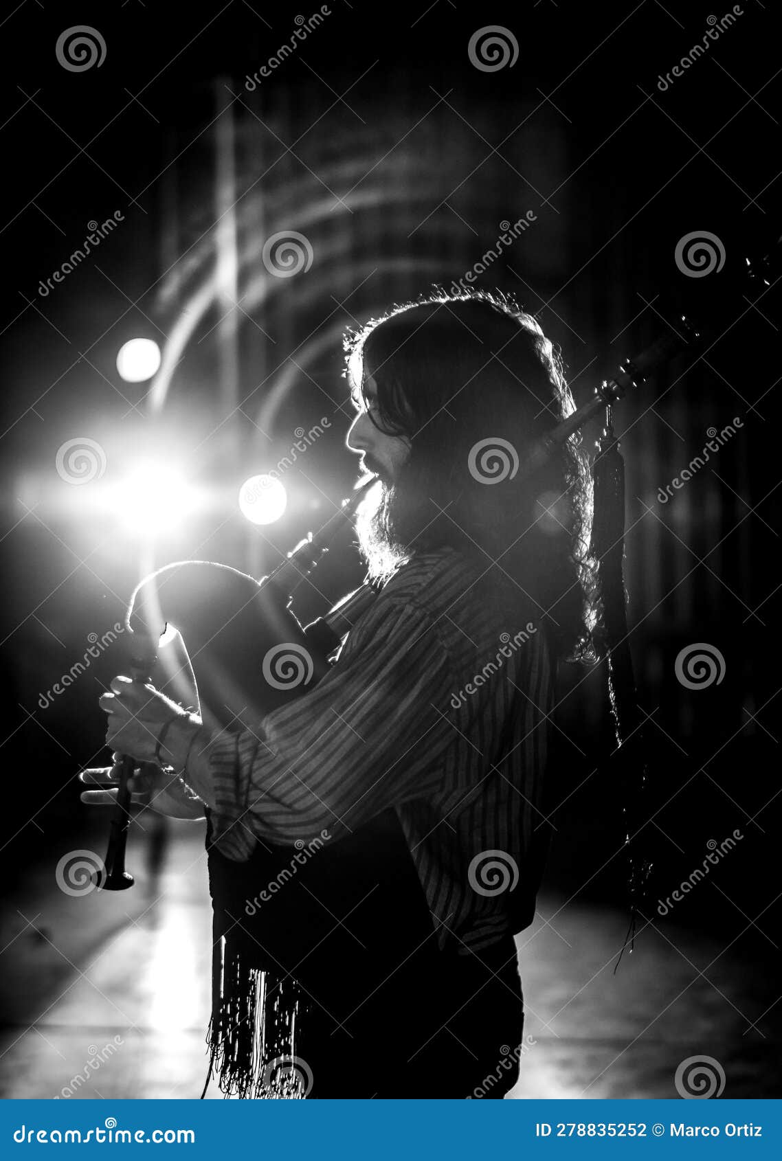 Bagpipe Player Playing His Instrument in an Auditorium with Stage ...