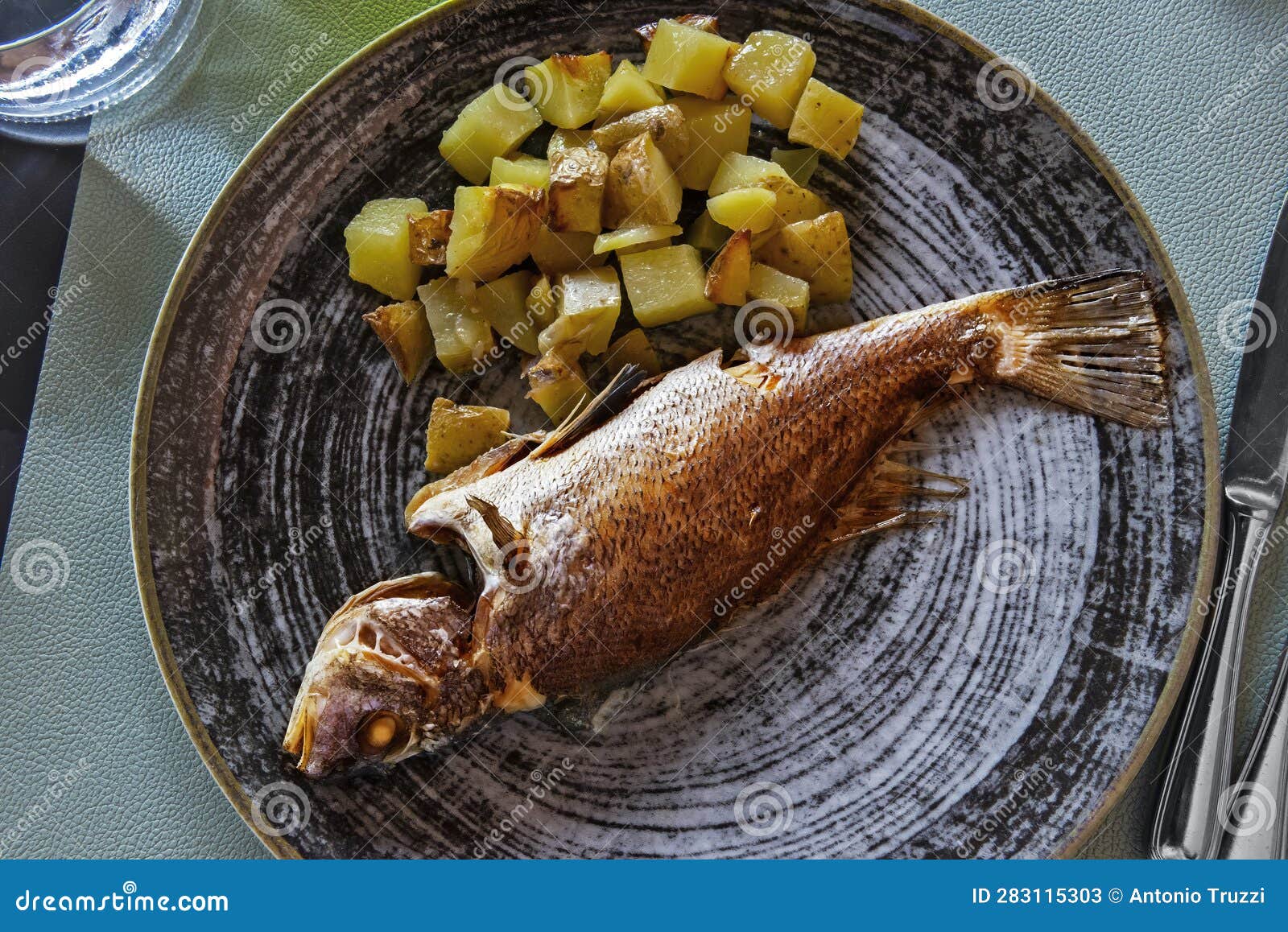 Baked fish with potatoes stock image. Image of portion - 283115303