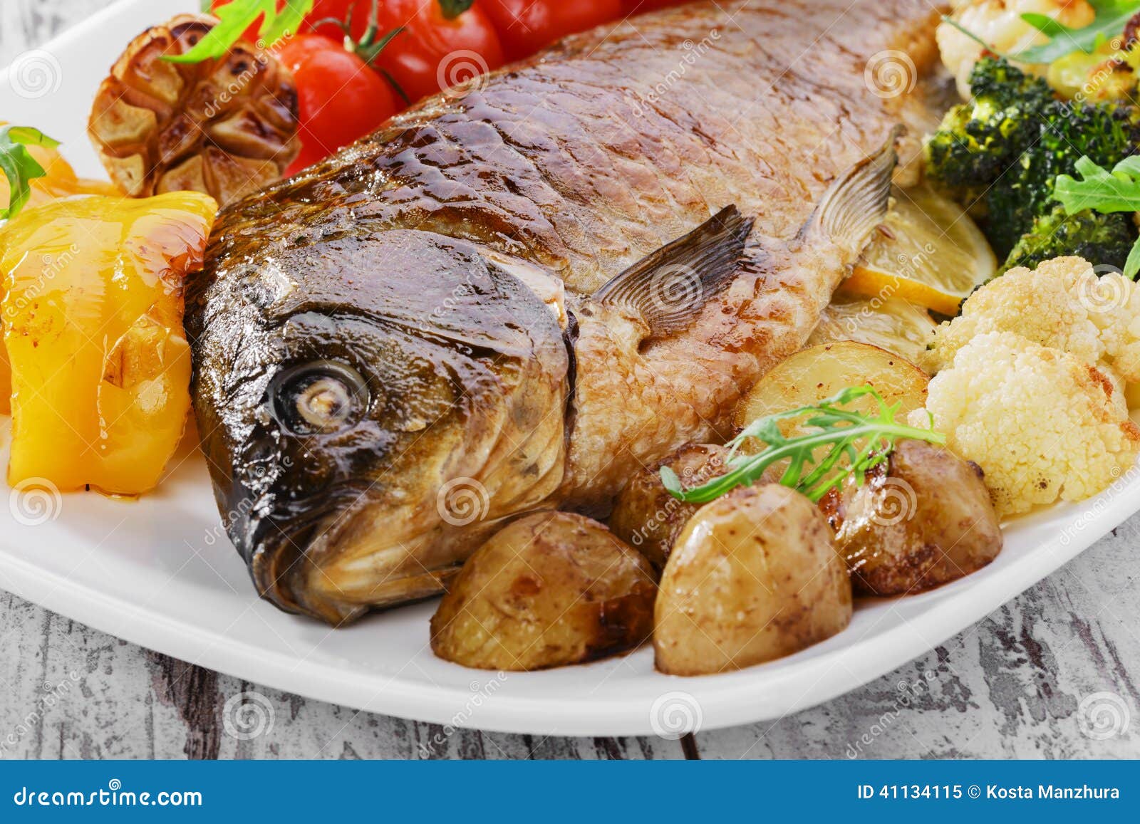 Baked fish with vegetables stock image. Image of lemon - 41134115