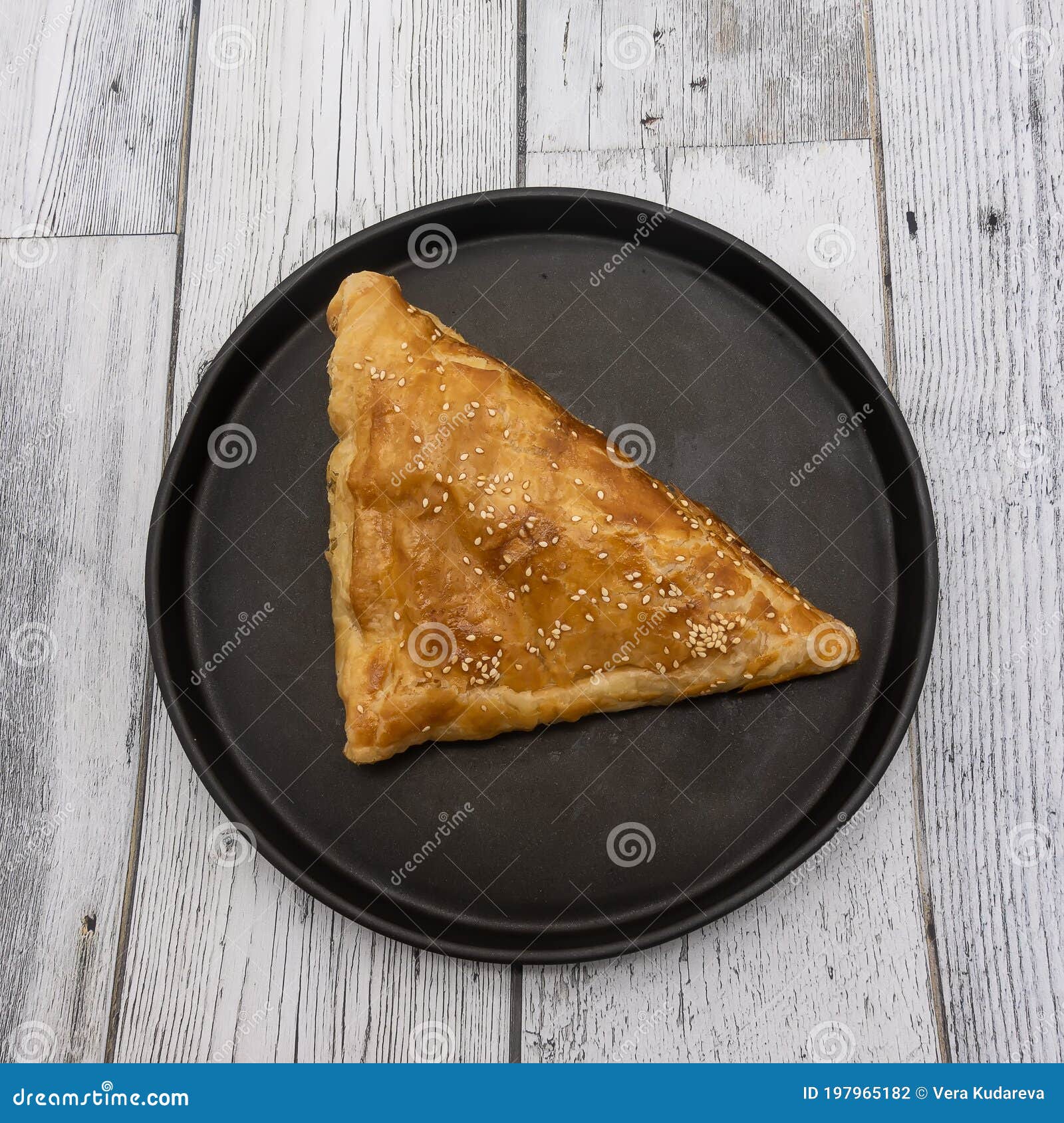 Baked Triangular Pie on a Round Black Baking Sheet. Stock Photo - Image ...
