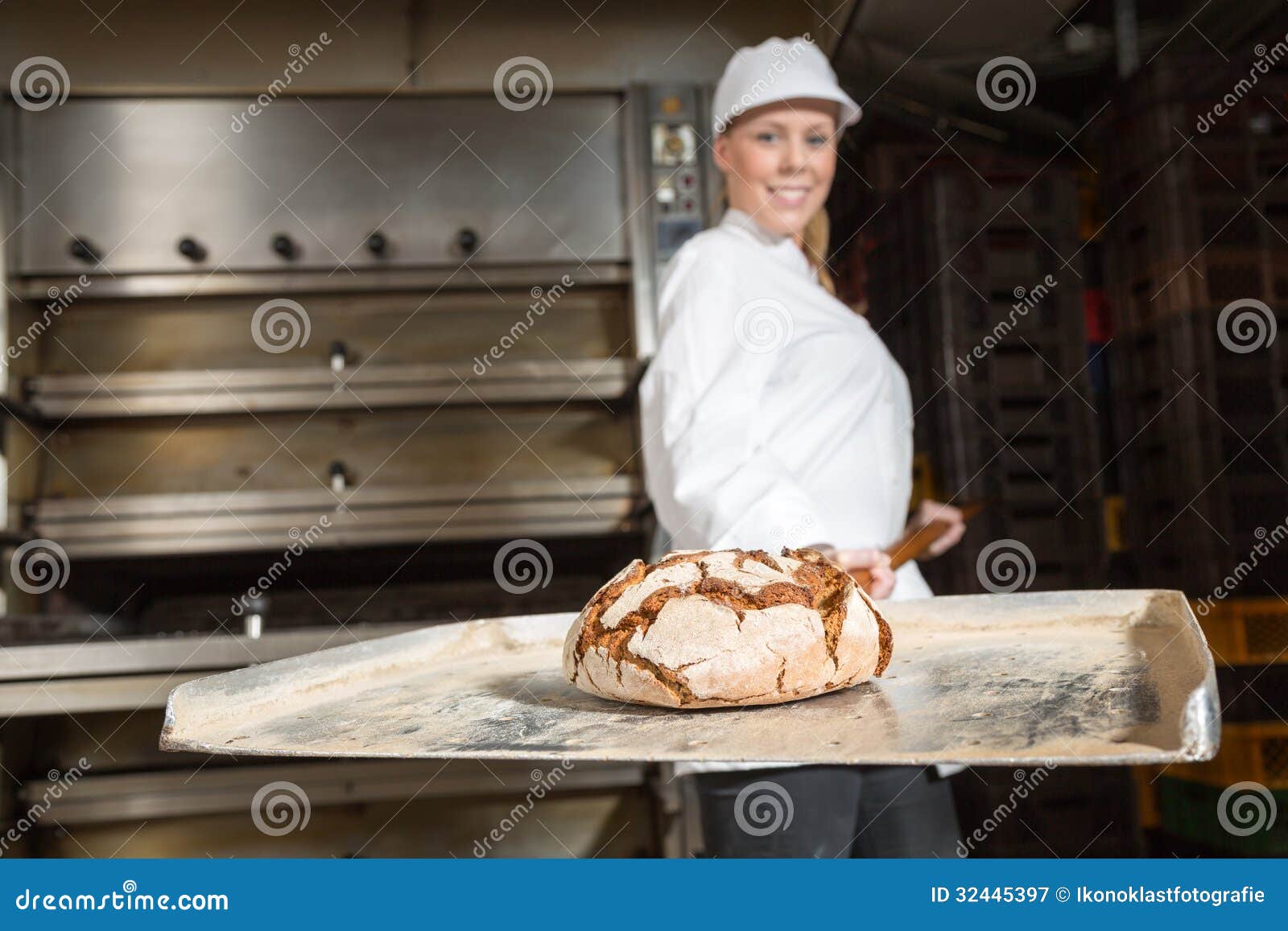 Baker in Bakery Presents Loaf of Bread on a Peel Stock Image - Image of ...