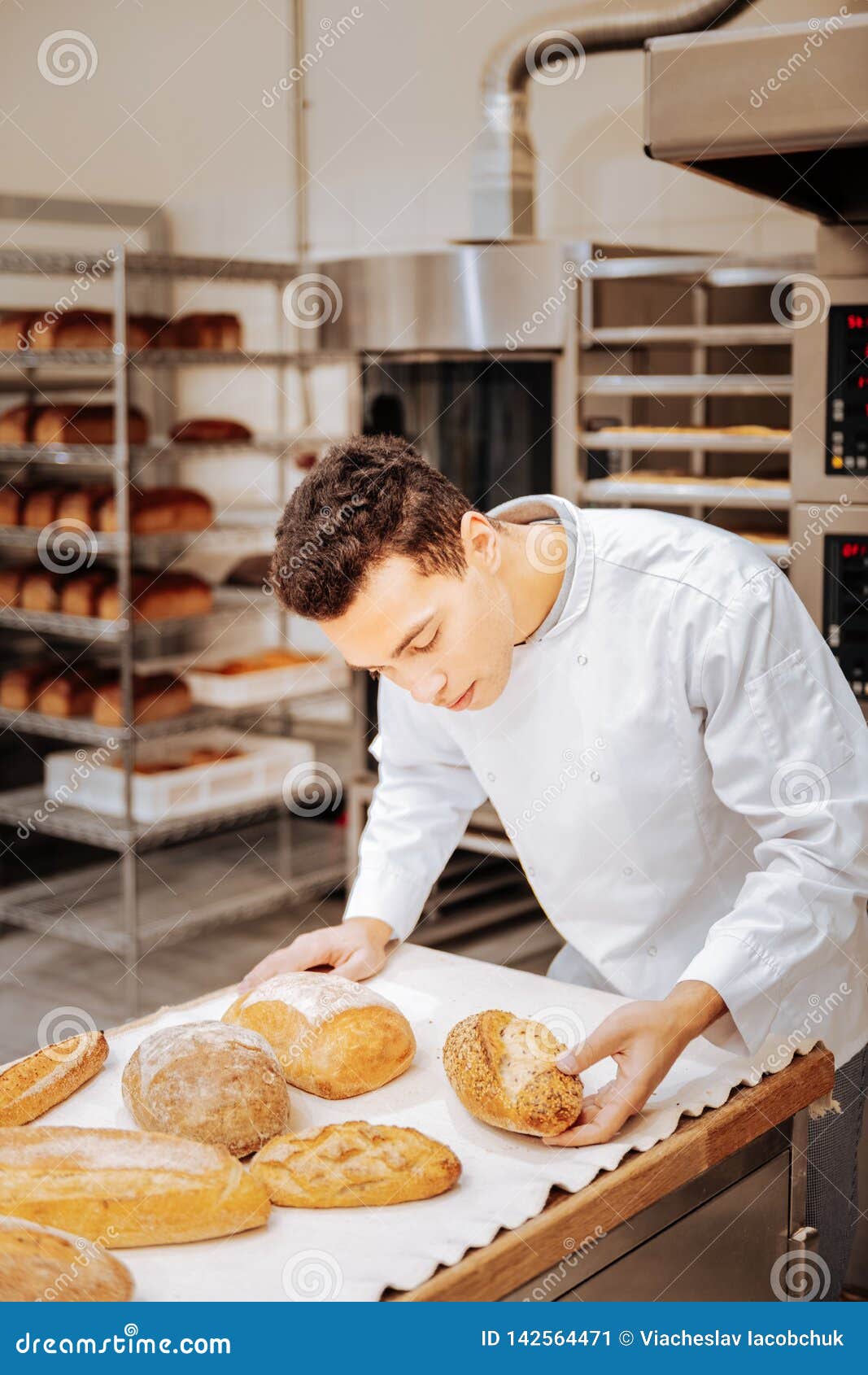 Baker Looking at the Tray and Checking the Readiness of Bread Stock ...