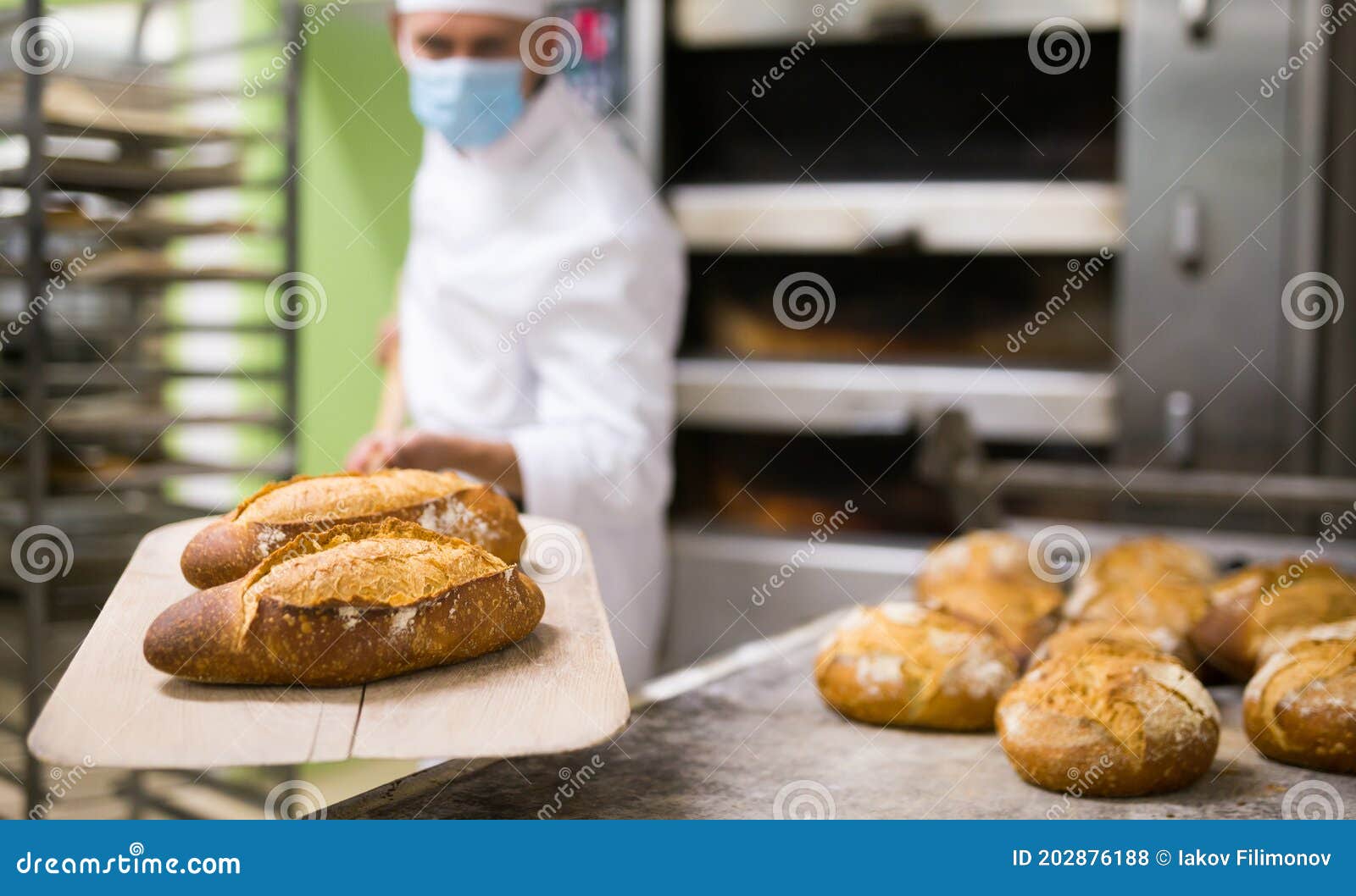 Baker Takes Out Hot Bread from Oven Stock Photo - Image of commerce ...