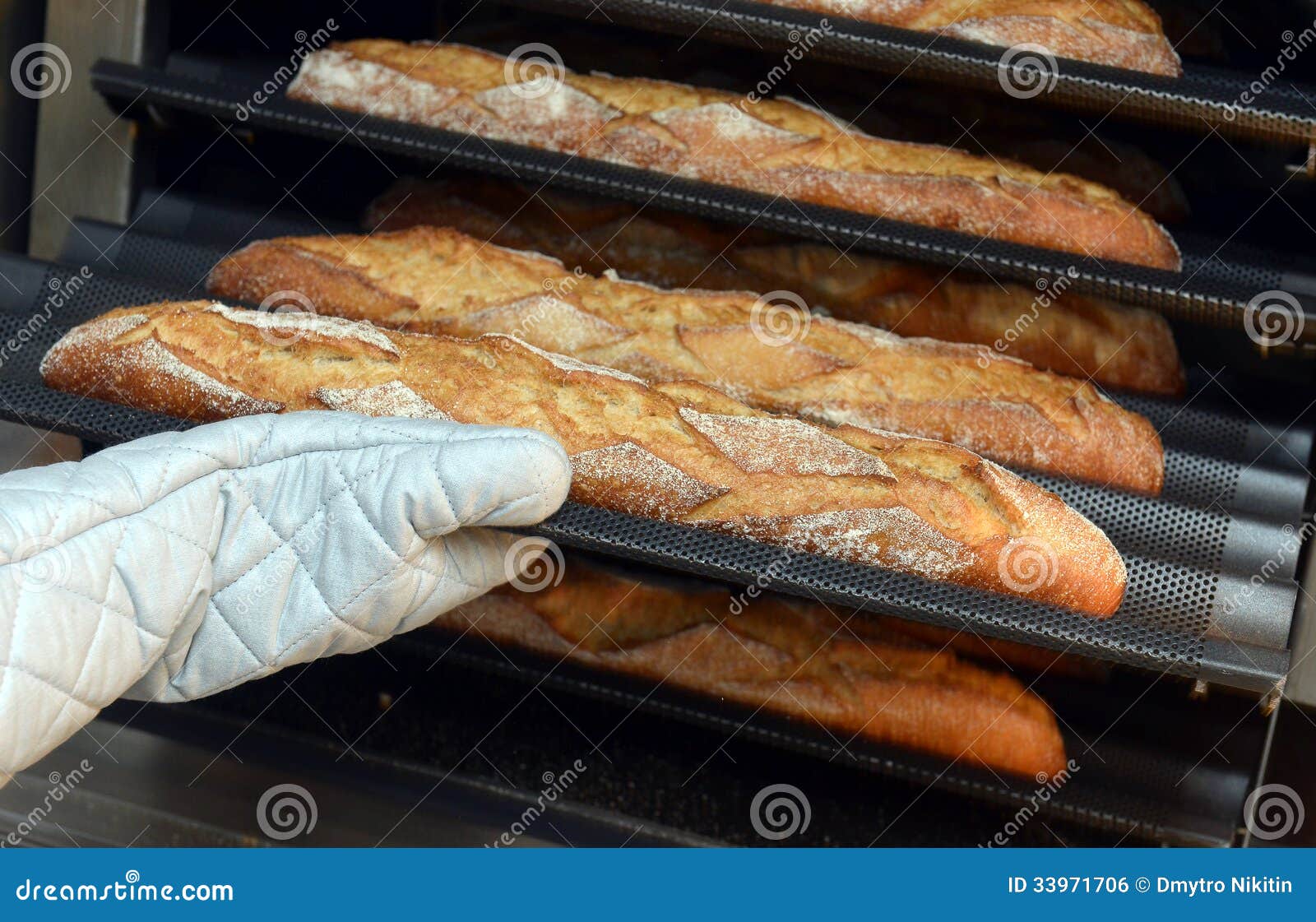 Baker Taking a Loaf of Freshly Baked Bread from the Oven Stock Photo ...