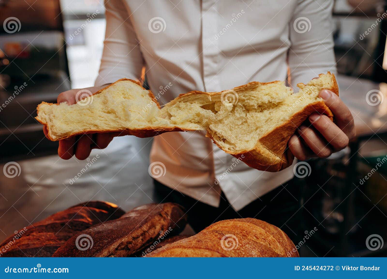 Baker in Uniform Breaks Freshly Baked Bread at the Bakery Stock Photo ...