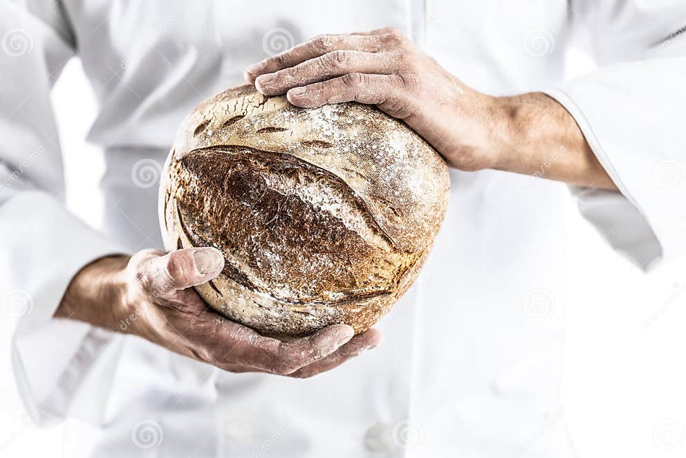 A Baker in White Work Clothes is Holding a Fresh Loaf of Bread Stock ...