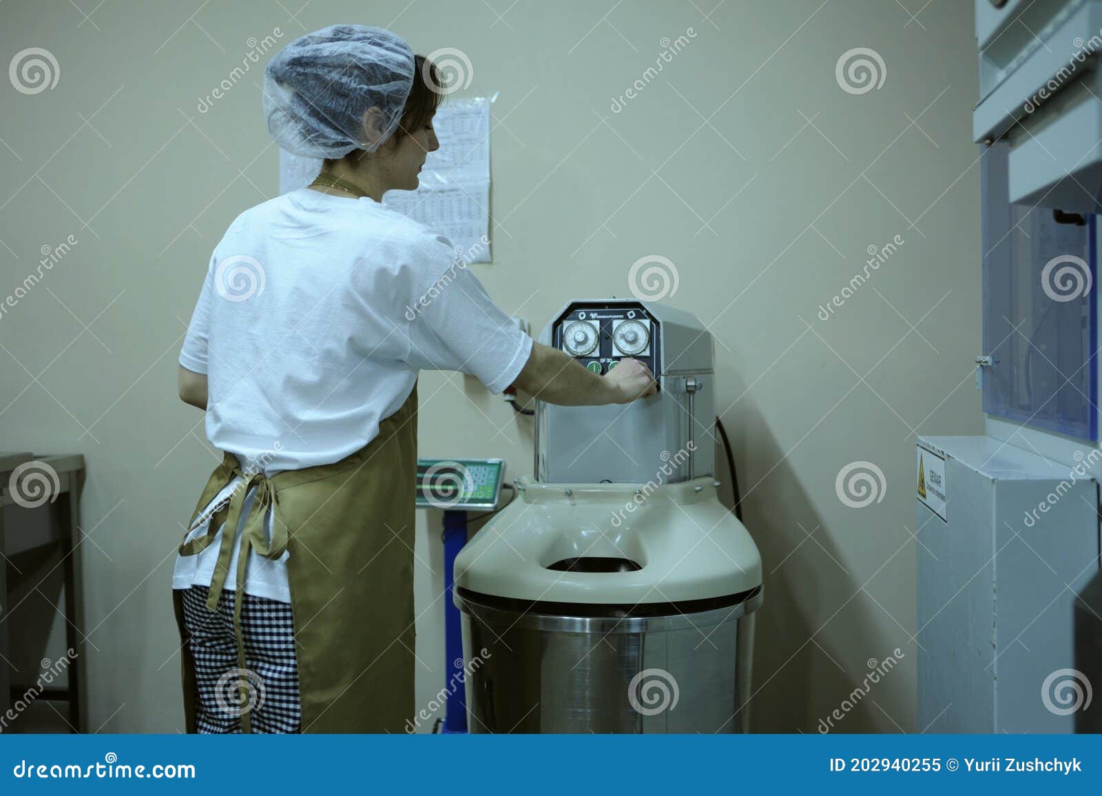 At the Bakery: Baker Standing Near Dough Mixing Machine and Regulating ...
