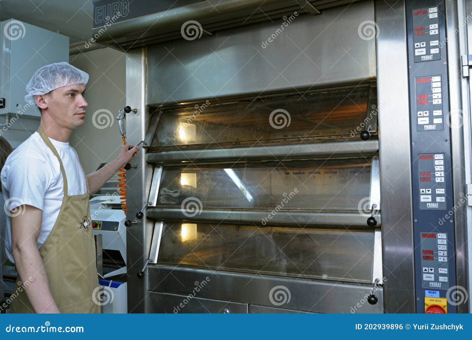At the Bakery: Baker Standing Near an Electric Oven Watching ...