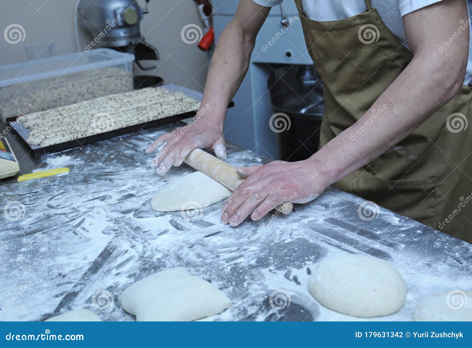 At the Bakery: Baker Standing at the Work Table and Forming Dough for ...