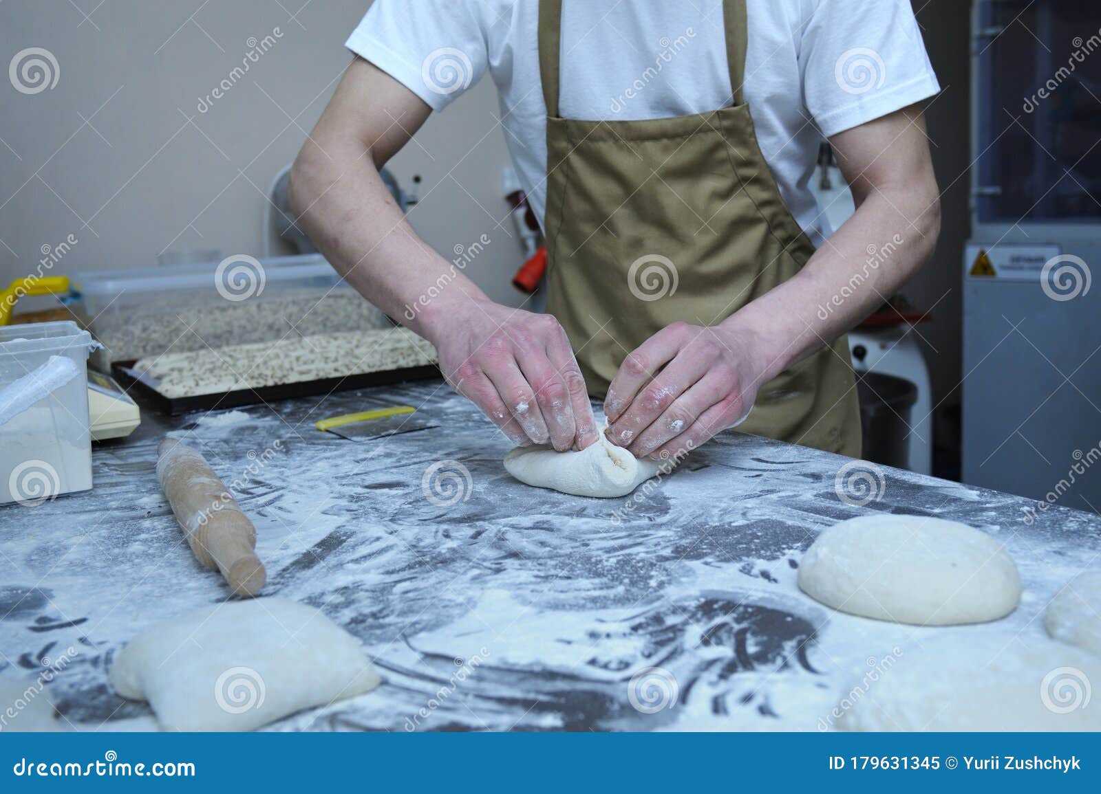 At the Bakery: Baker Standing at the Work Table and Forming Dough for ...