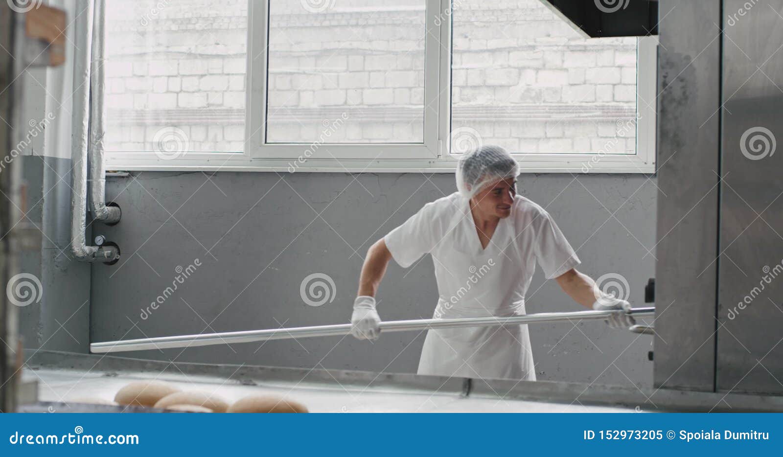 Bakery Worker Equipped in a White Uniform Take the Bread from ...