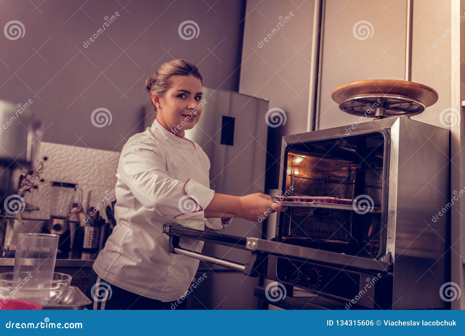 Delighted Female Pastry Chef Using the Oven Stock Photo - Image of ...