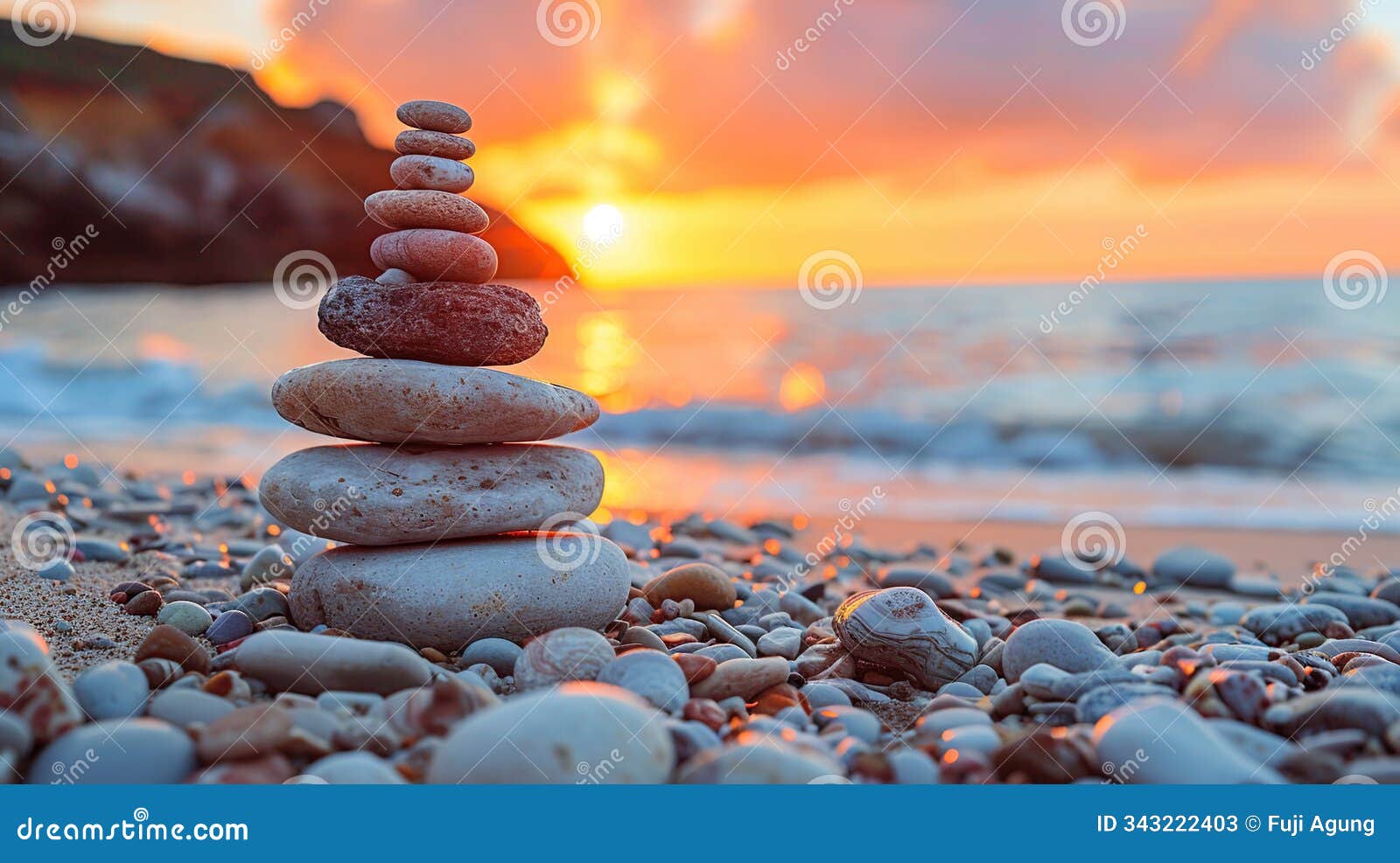 A Balanced Stack of Smooth Stones on a Sandy Beach at Sunset, with the ...