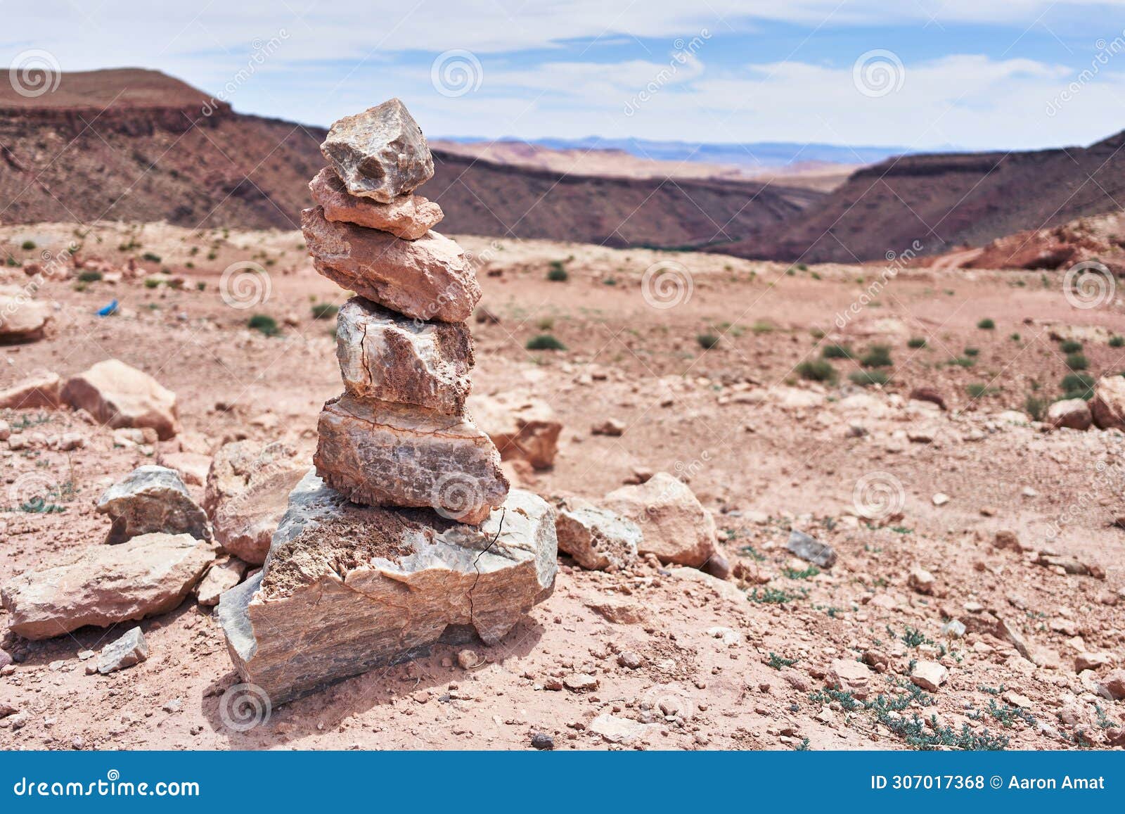 A Balanced Stack of Stones Stands in the Forefront of a Vast, Arid ...