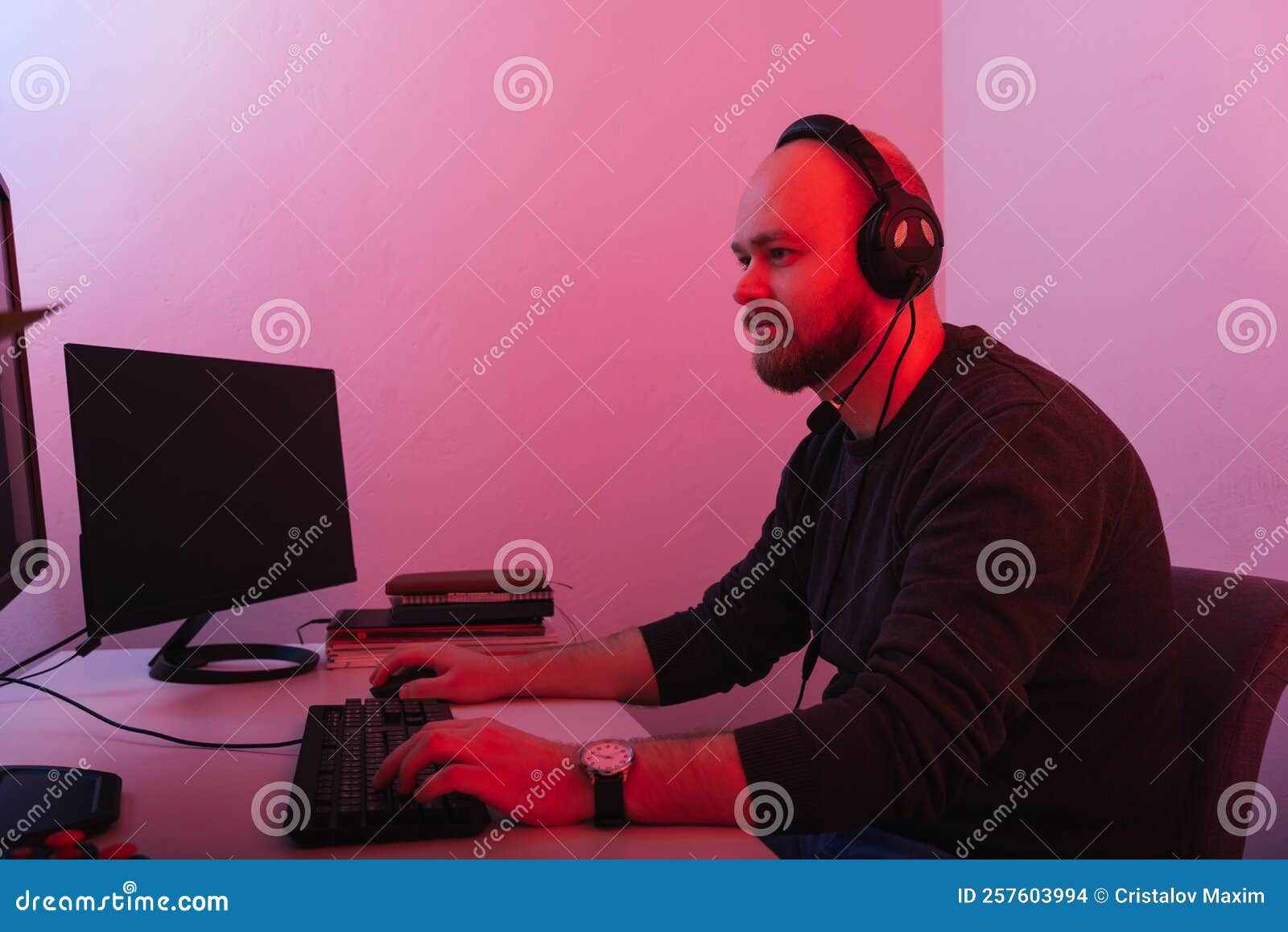 Bald Bearded Man Wearing Headset is Sitting and Working at the Computer ...