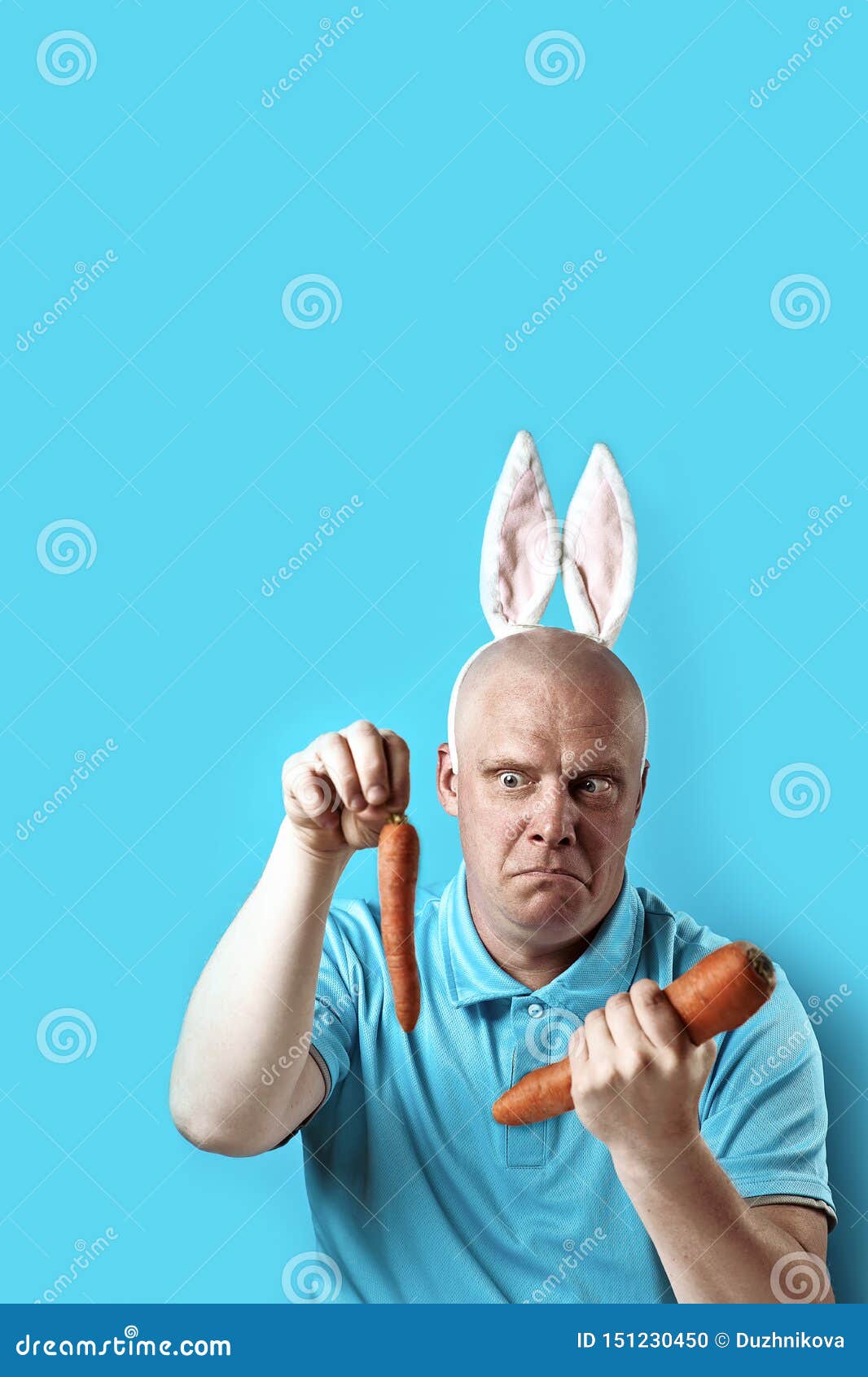 Bald Brutal Man in Light T-shirt and Rabbit Ears. in His Hands he Holds ... Bald Brutal Man in Light T-shirt and Rabbit Ears. in His Hands he Holds ...