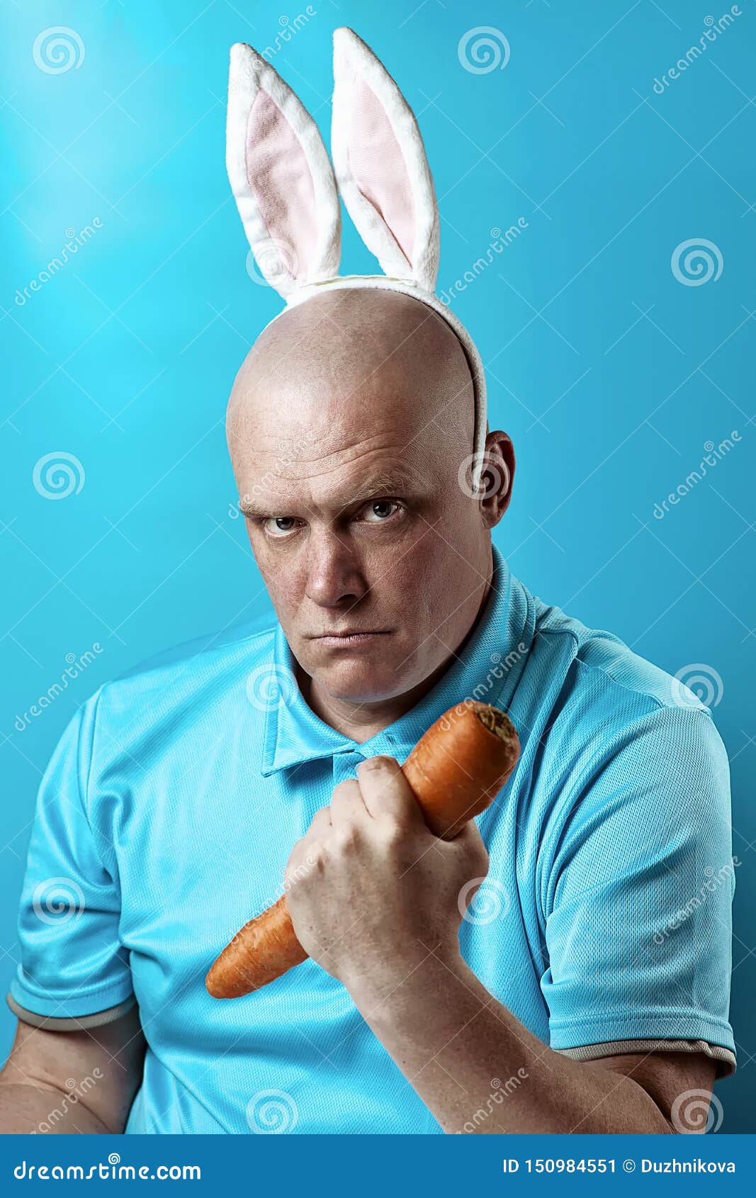 Bald Brutal Man in Light T-shirt and Rabbit Ears. in His Hands he Holds ... Bald Brutal Man in Light T-shirt and Rabbit Ears. in His Hands he Holds ...