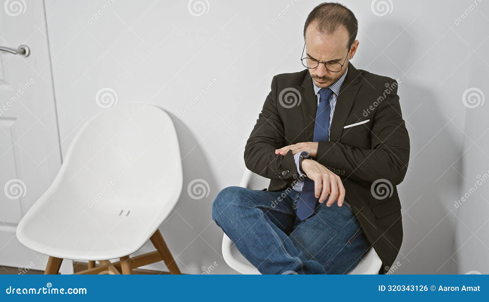 Bald Man in Suit Checking Time while Sitting Alone in a Minimalist ...