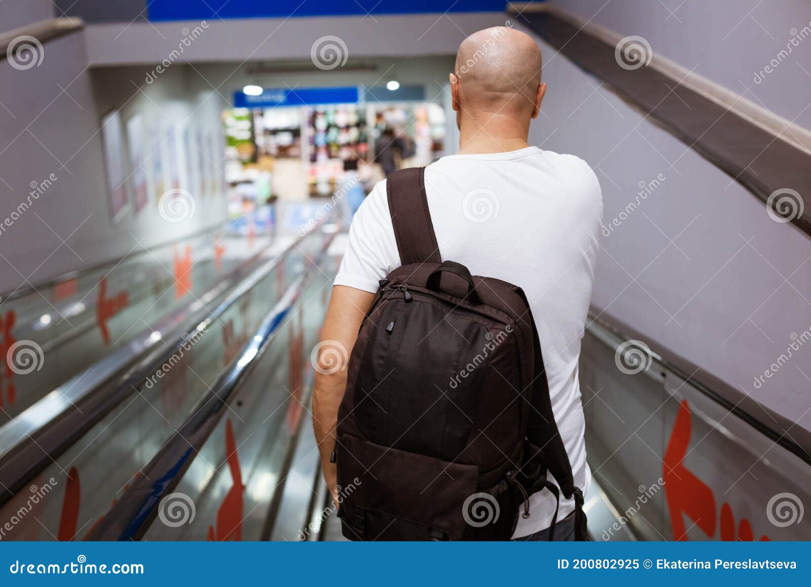 Bald Man Walking Down the Escalator with a Backpack Stock Image - Image ...