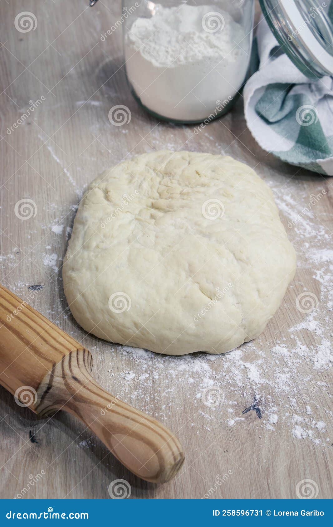Ball of Dough on a Wooden Table Surrounded by a Rolling Pin, a Jar with ...