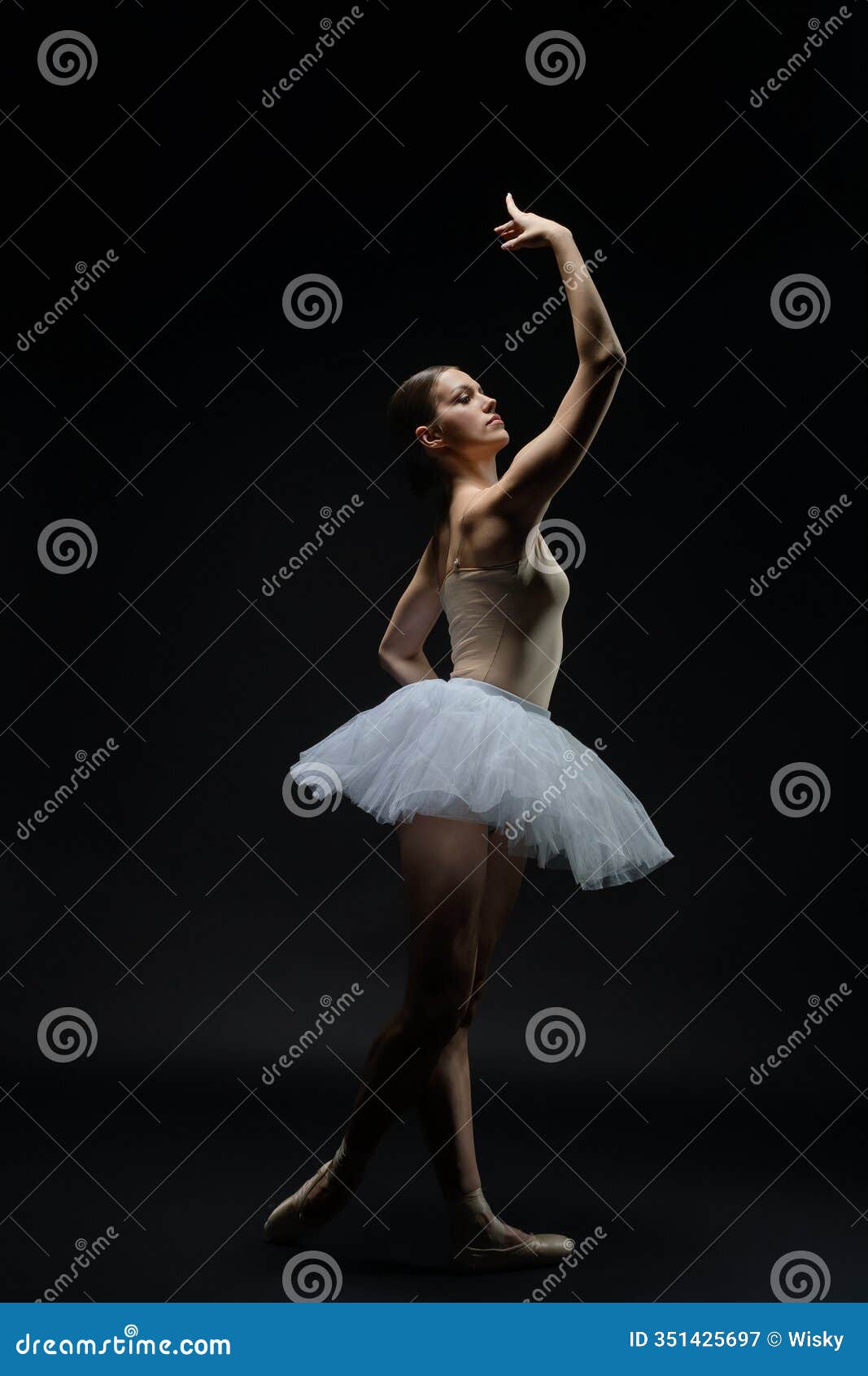 Ballet Dancer Performing in a Graceful Pose Under Dramatic Lighting ...