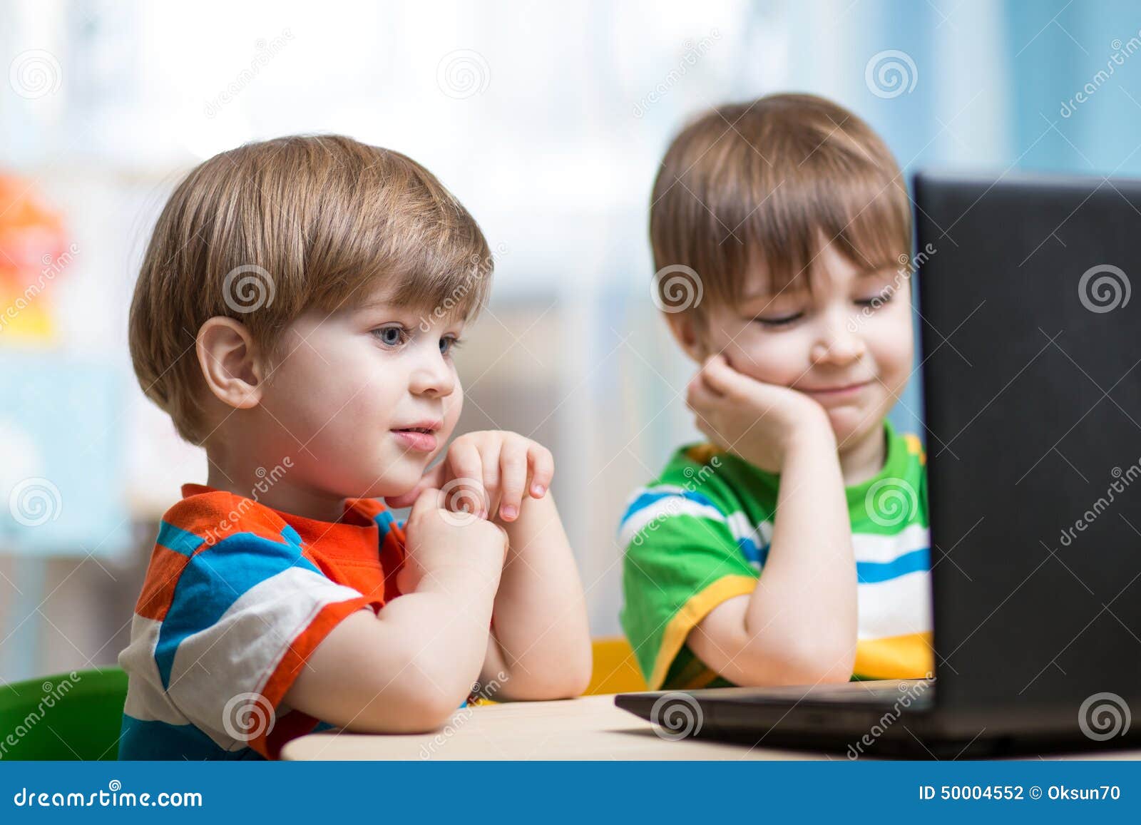 Bambini Felici Che Esaminano Computer Portatile Fotografia Stock ...