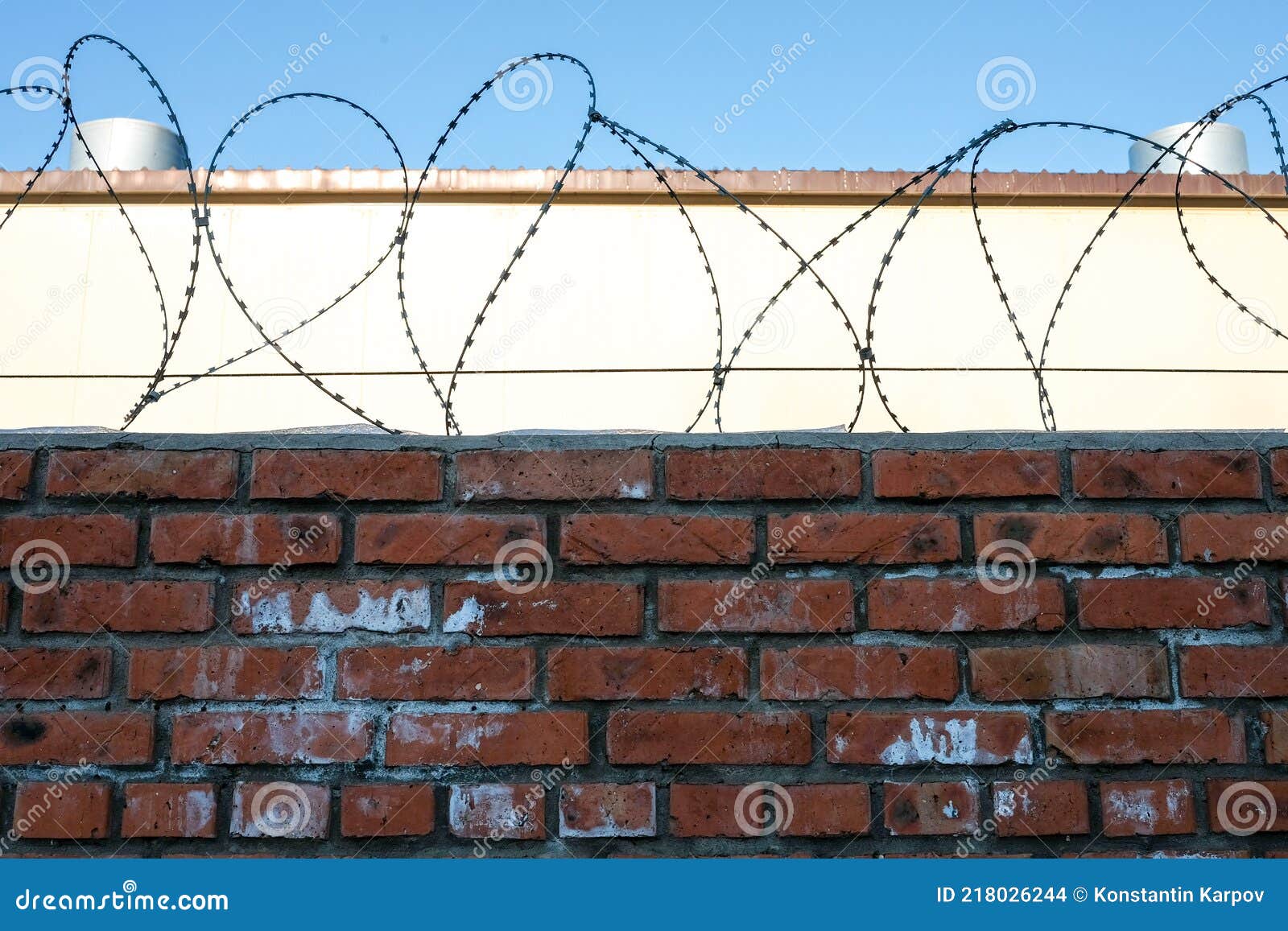 Barbed Wire with Brick Wall and Light Building in the Background ...